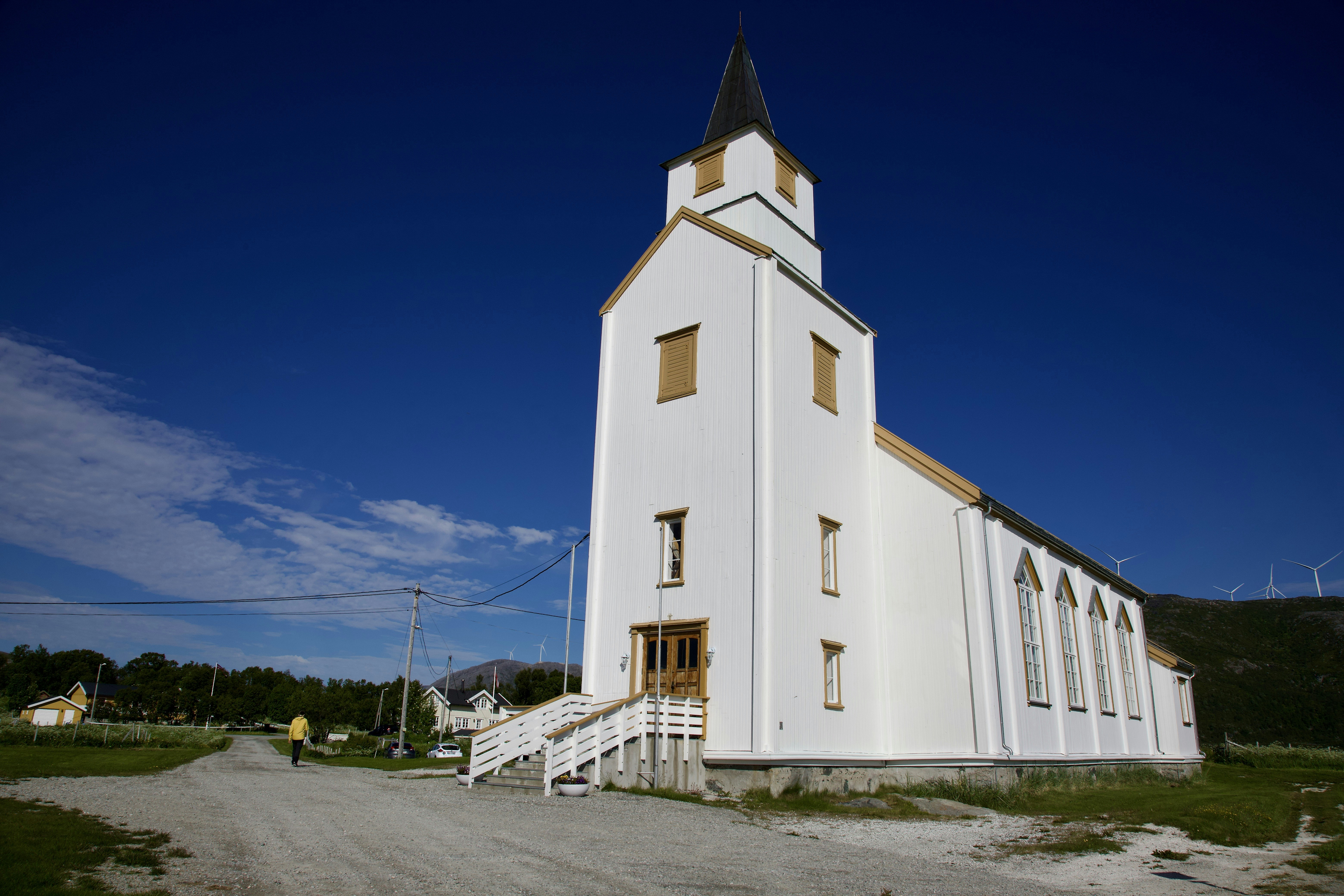 a large white church with a steeple on a clear day