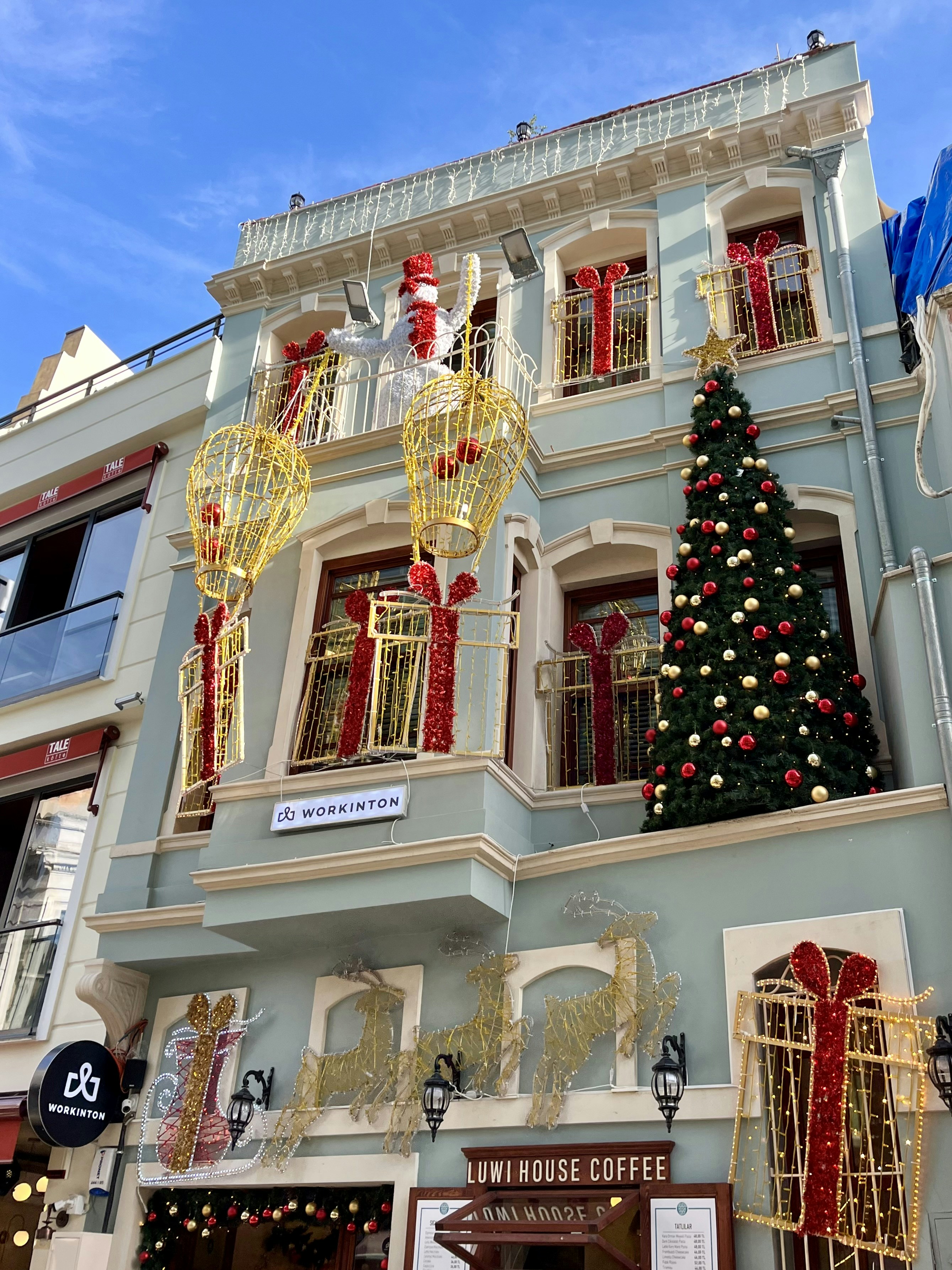 A tall building with a christmas tree in front of it photo – Free ...