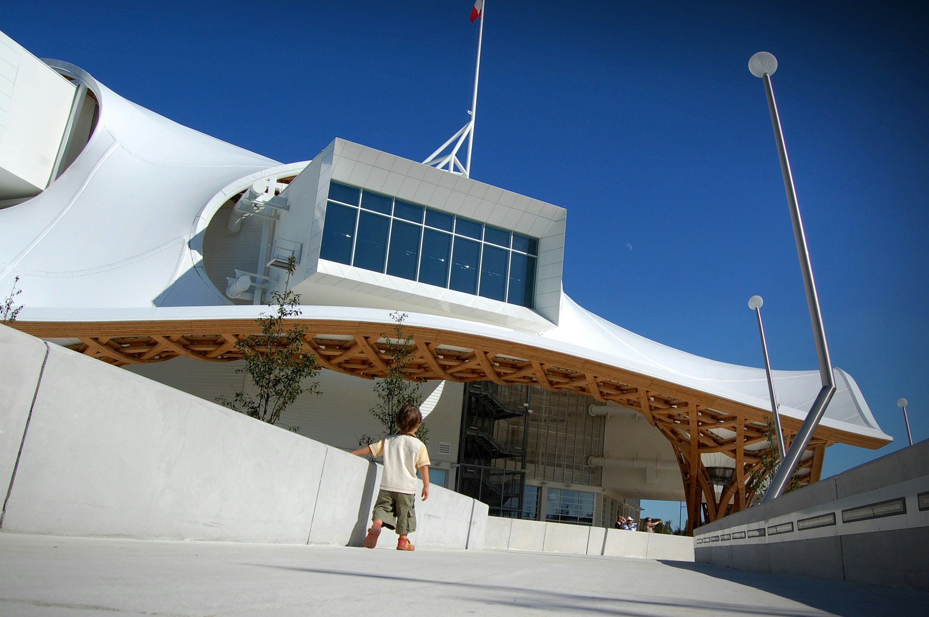 Modern architectural design of the Centre Pompidou-Metz with curved white roof against a deep blue sky.