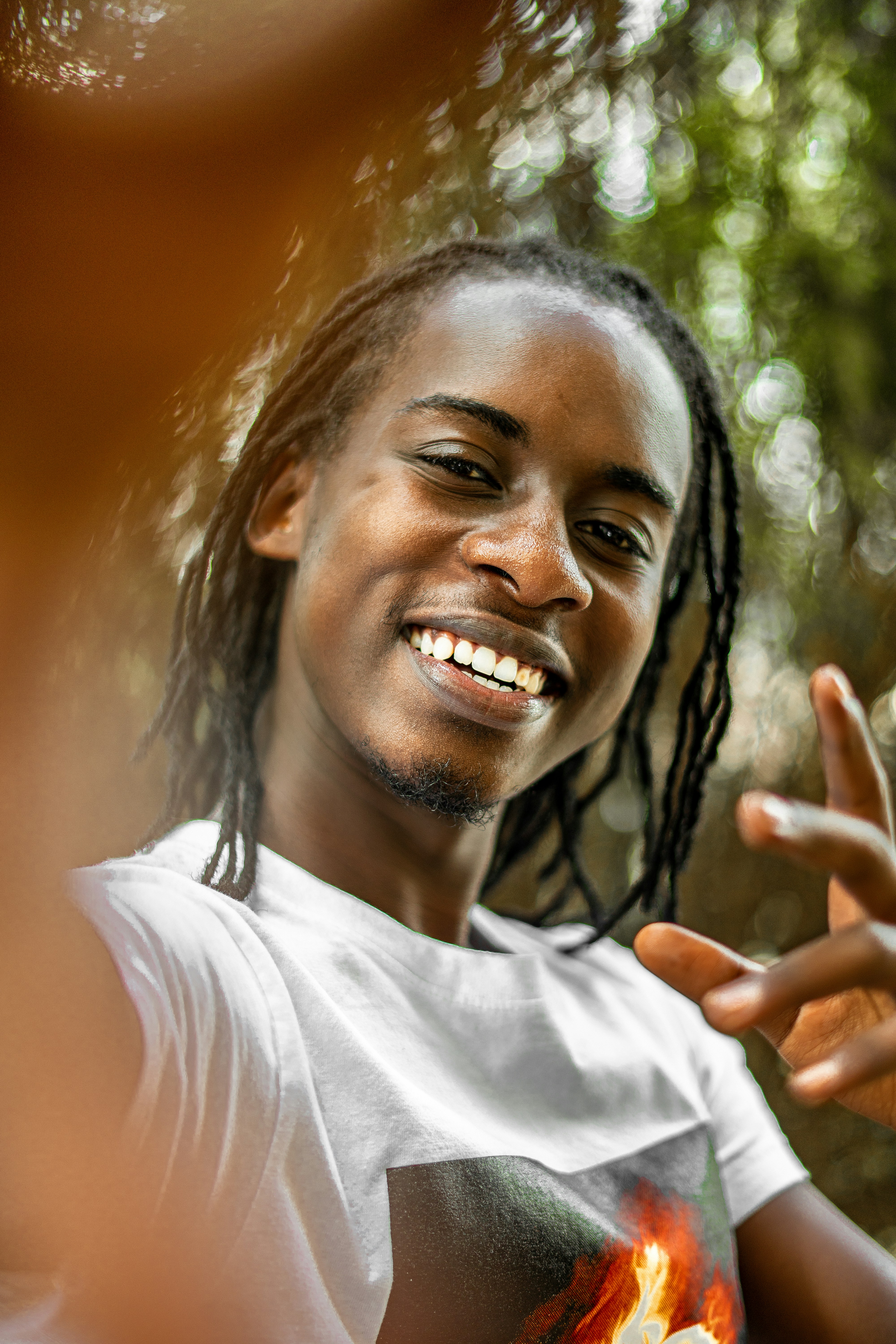 A man with dreadlocks smiles and holds his hand out photo – Free Person ...