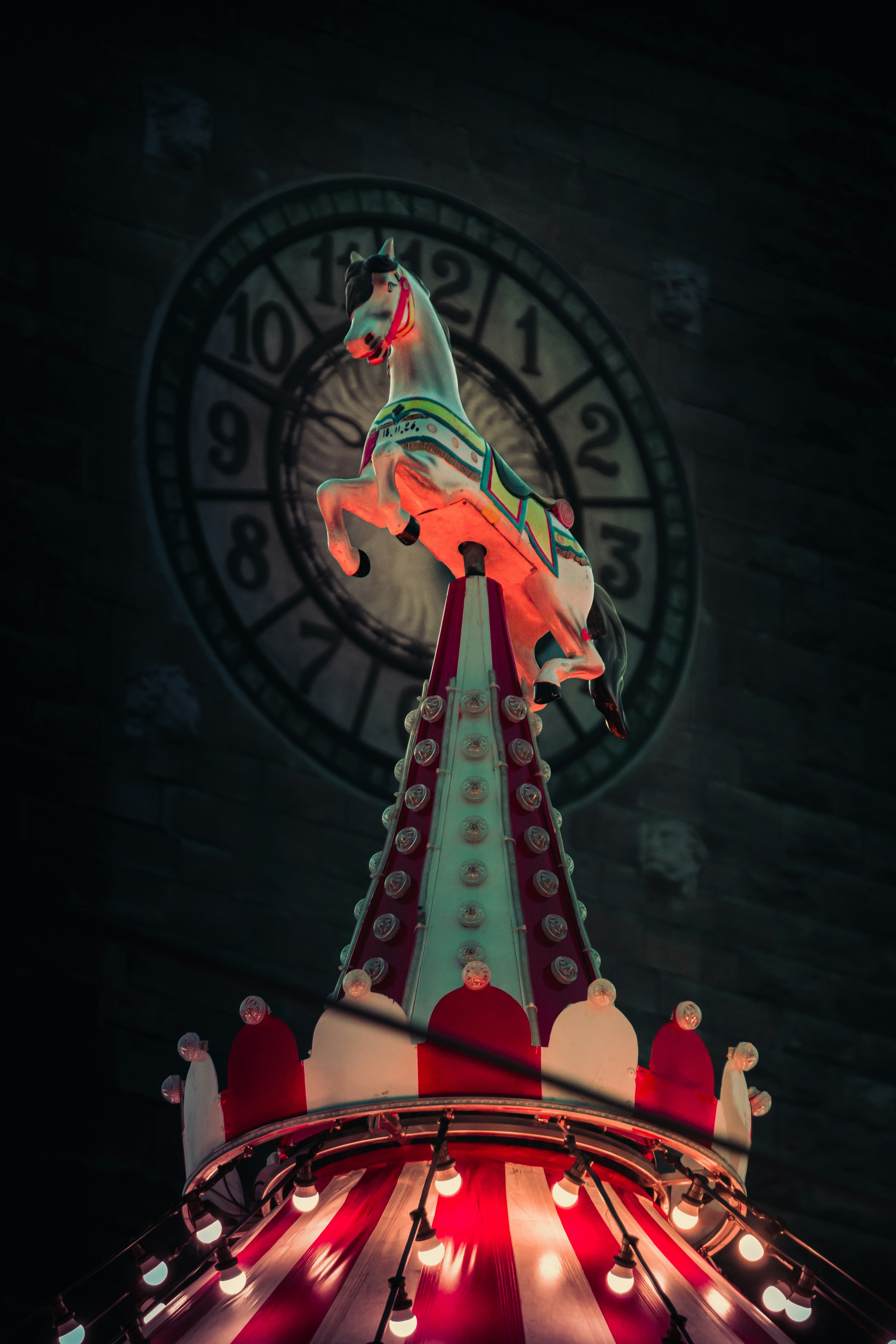 A carousel ride with a clock in the background photo – Free Bergamo ...