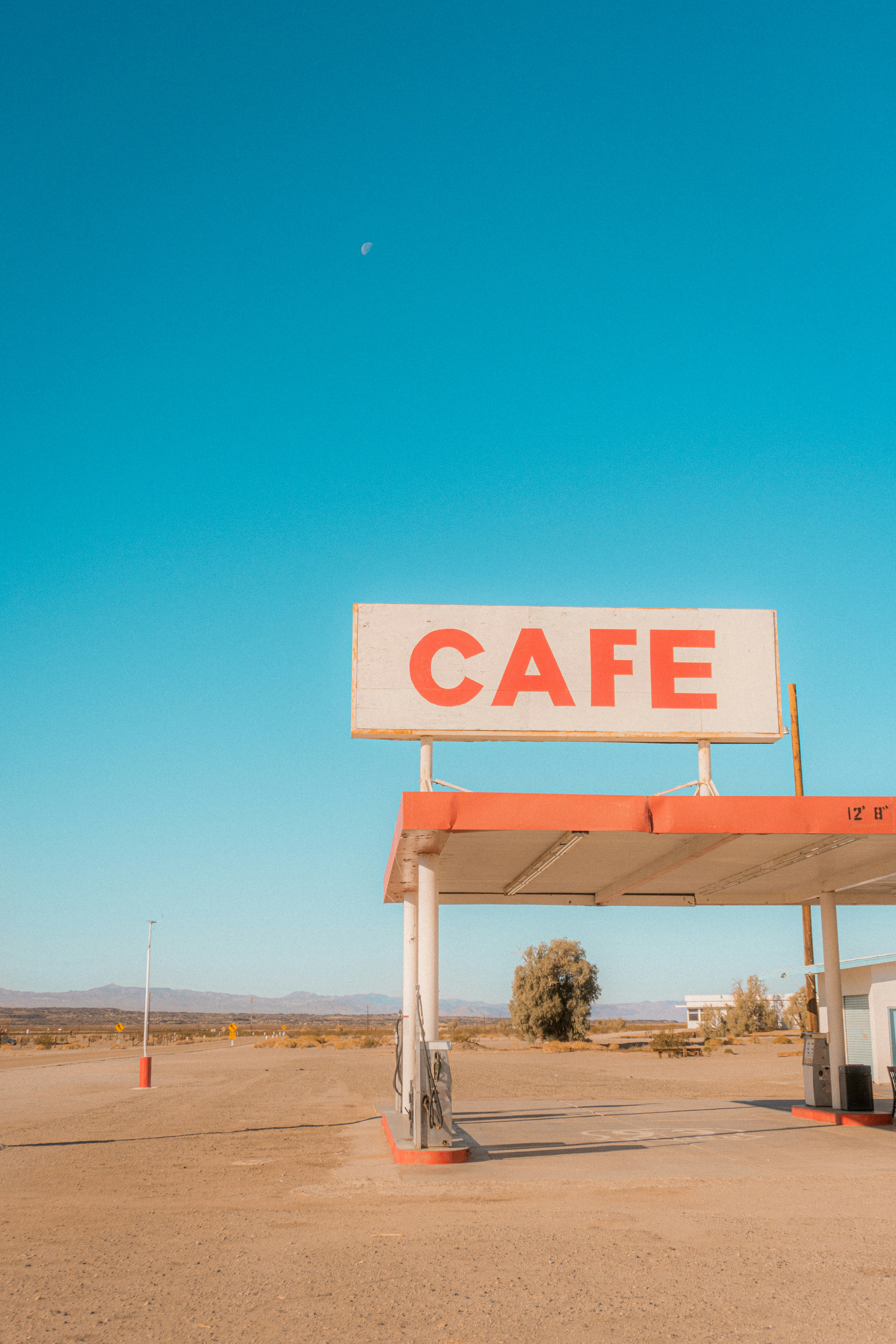 A gas station with a sign that says cafe photo – Free Gas station Image ...