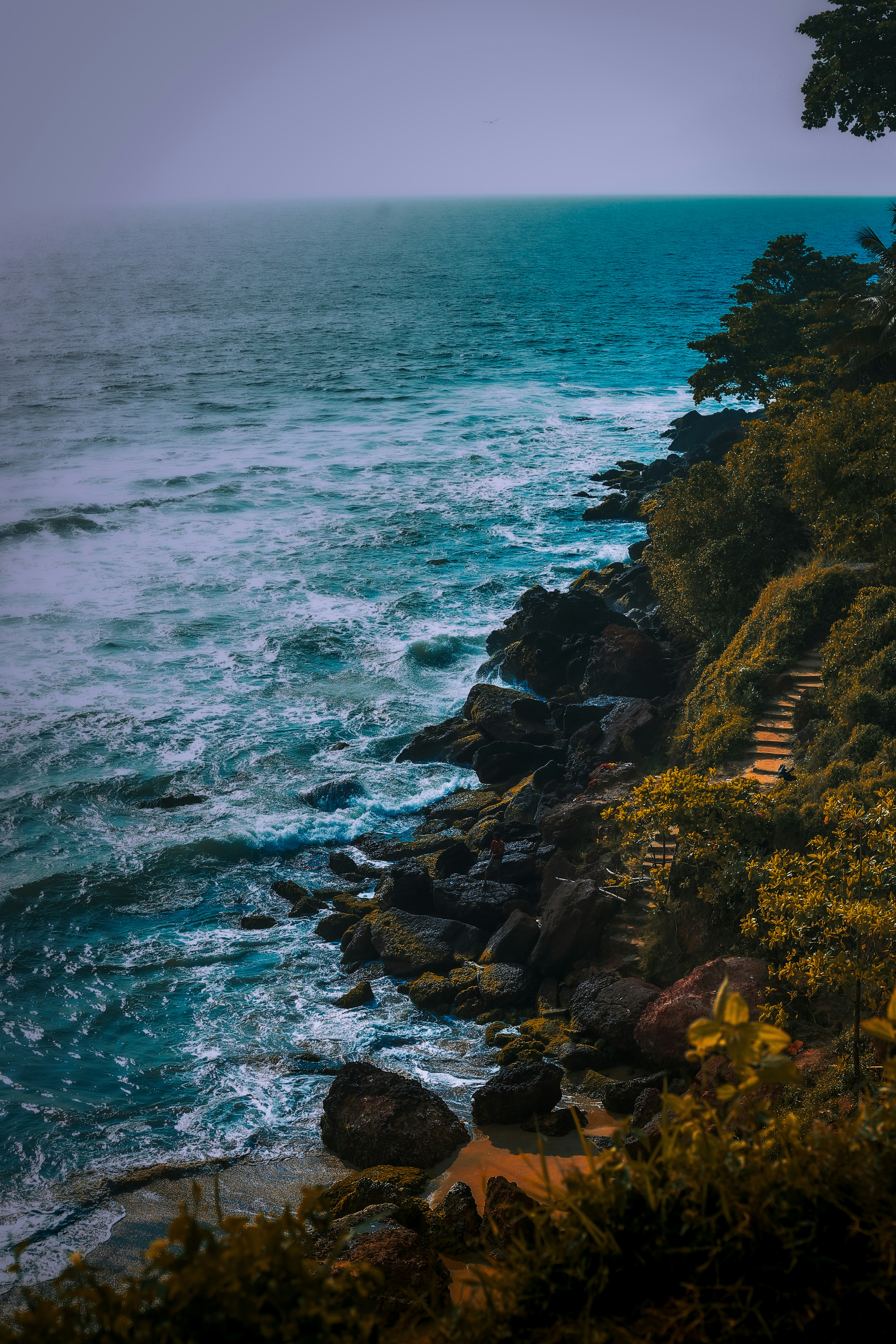 Foto Un banco sentado en la ladera de un acantilado cerca del océano ...