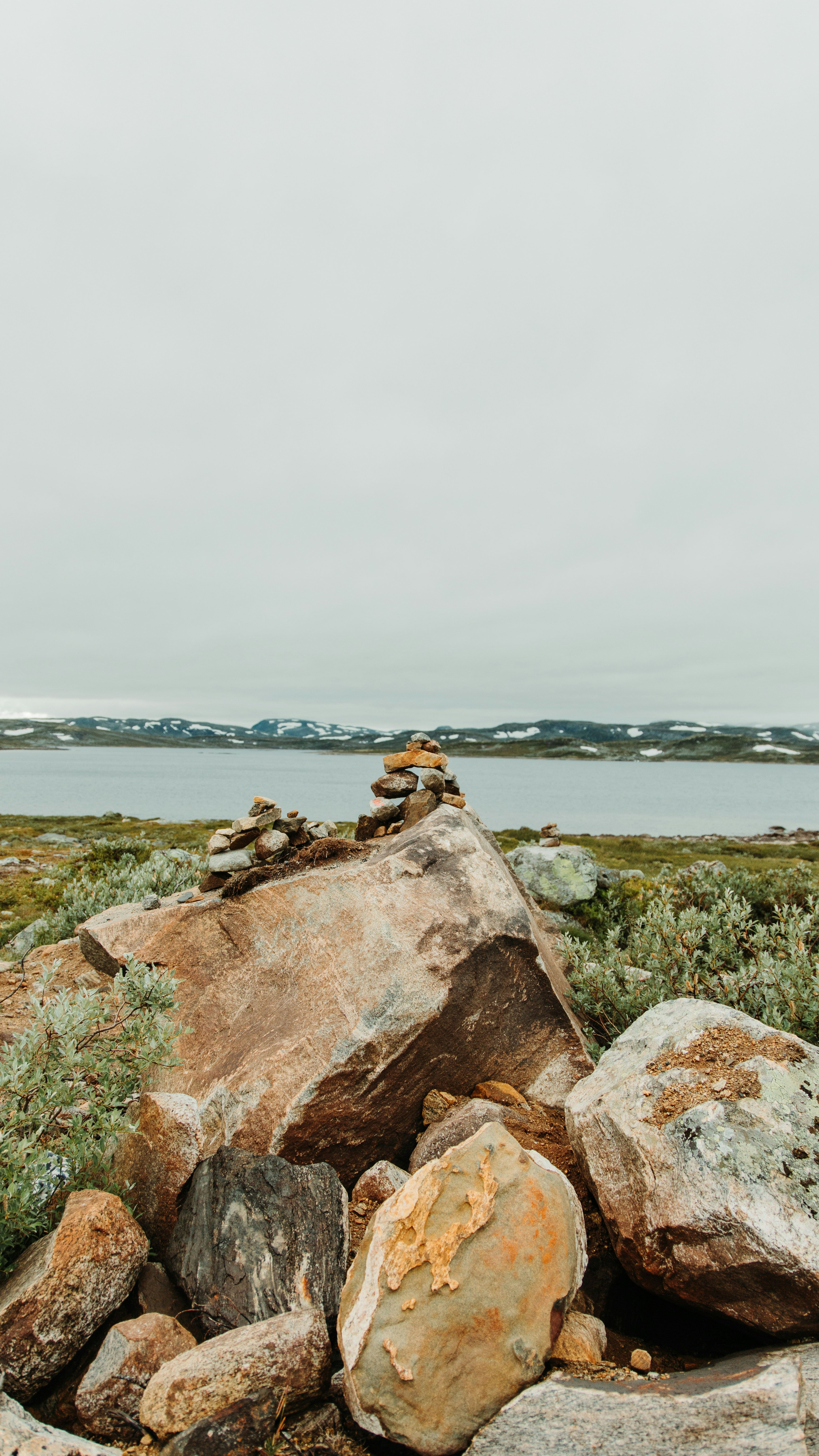 Norwegian Cairn in front of lake with snowy mountains