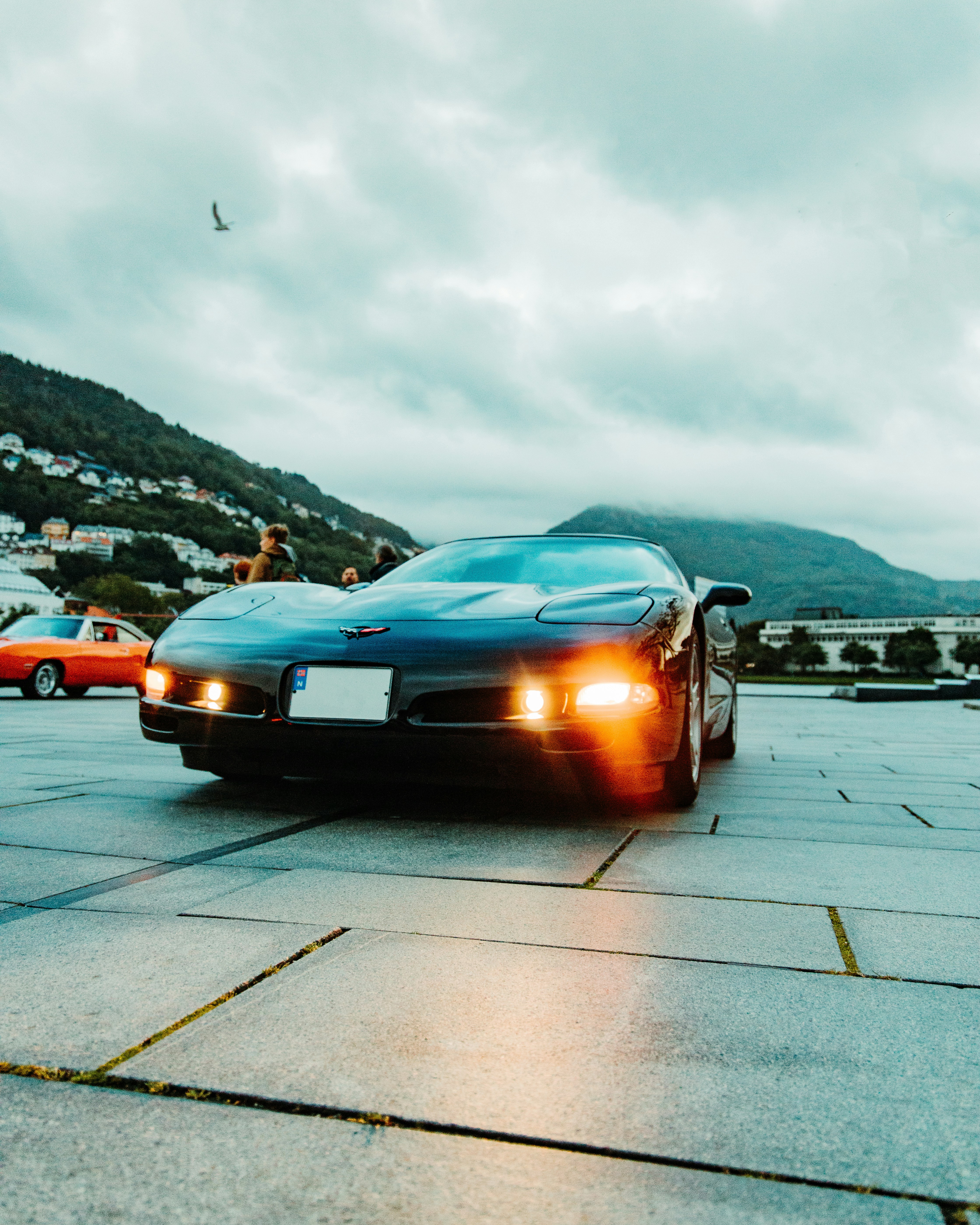 Frontal Mirage: Black Corvette on a Misty Seafront Promenade