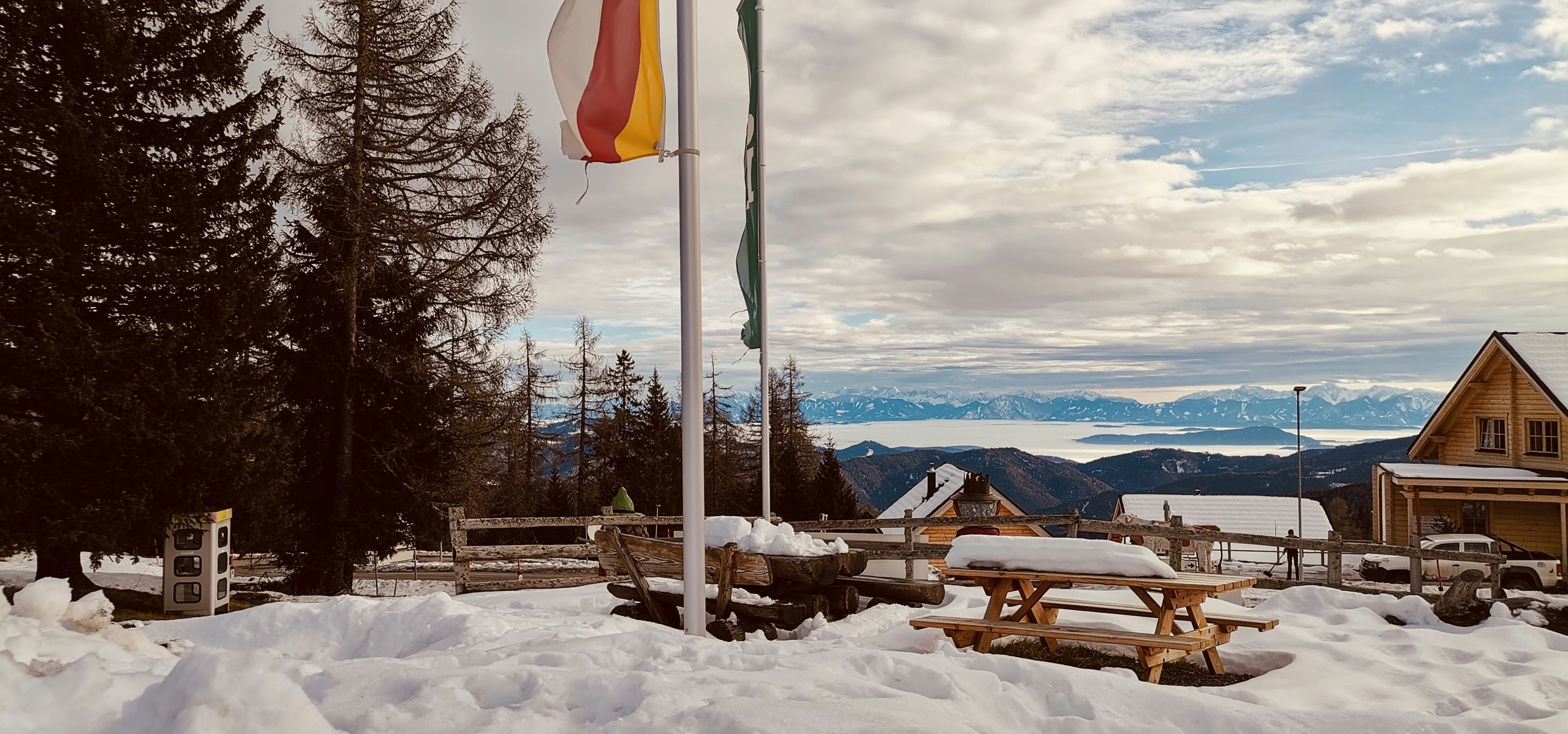 a picnic table with a flag on top of it in the snow