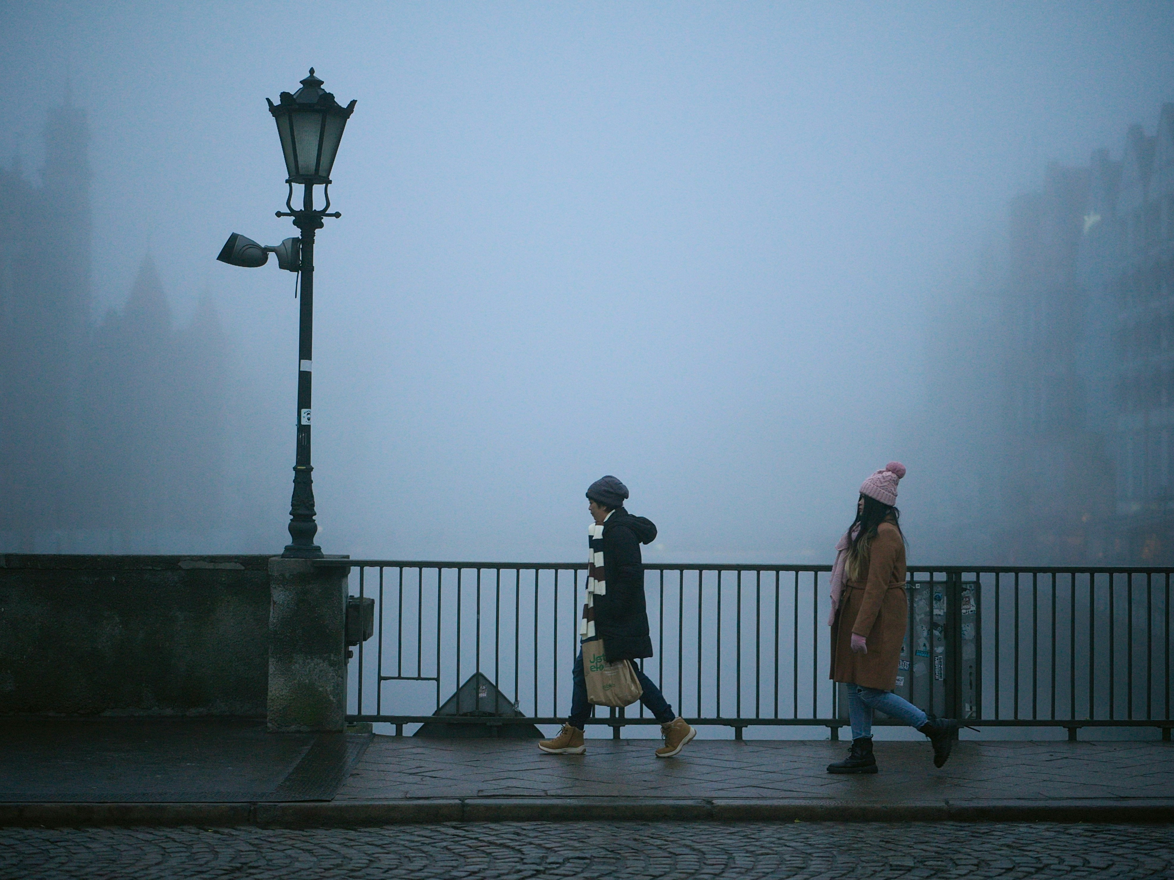 Mist-Wrapped Crossing: Two Figures on a Fogged Bridge