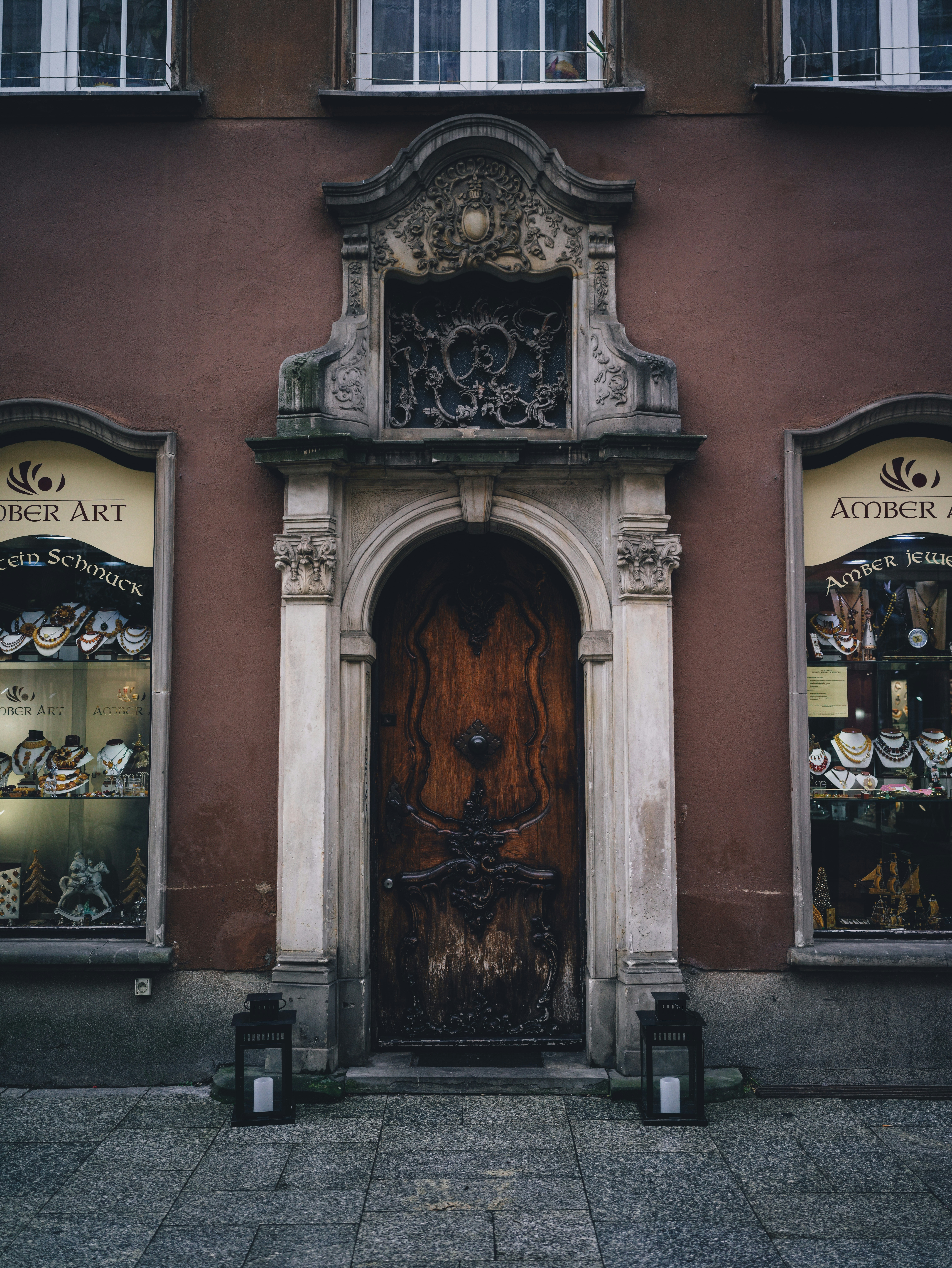 An Antique Portal Between Shopfronts: The Carved Door of a Heritage Façade