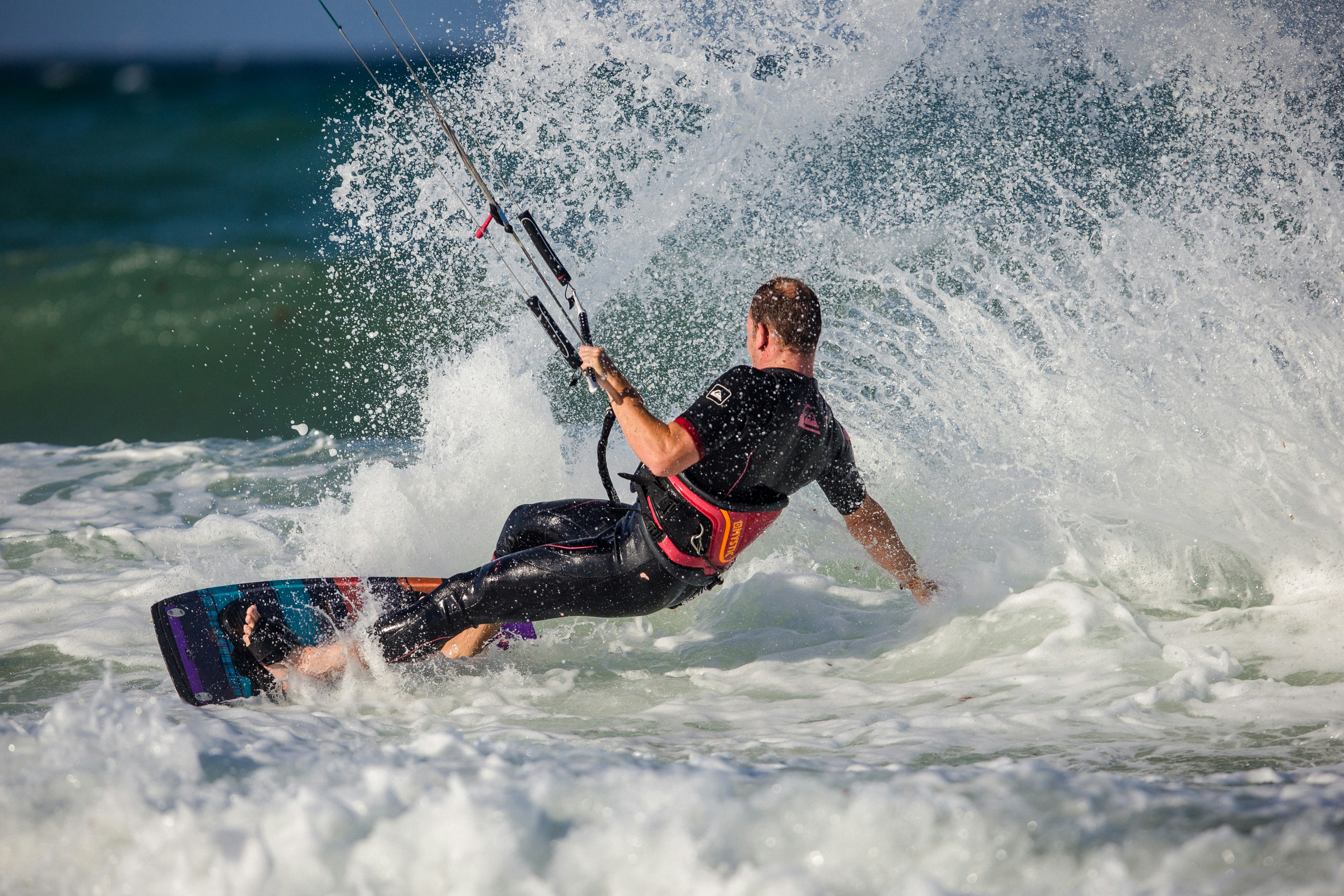 Kite and Water: A Rider Breaks the Crest of a Surfing Wave