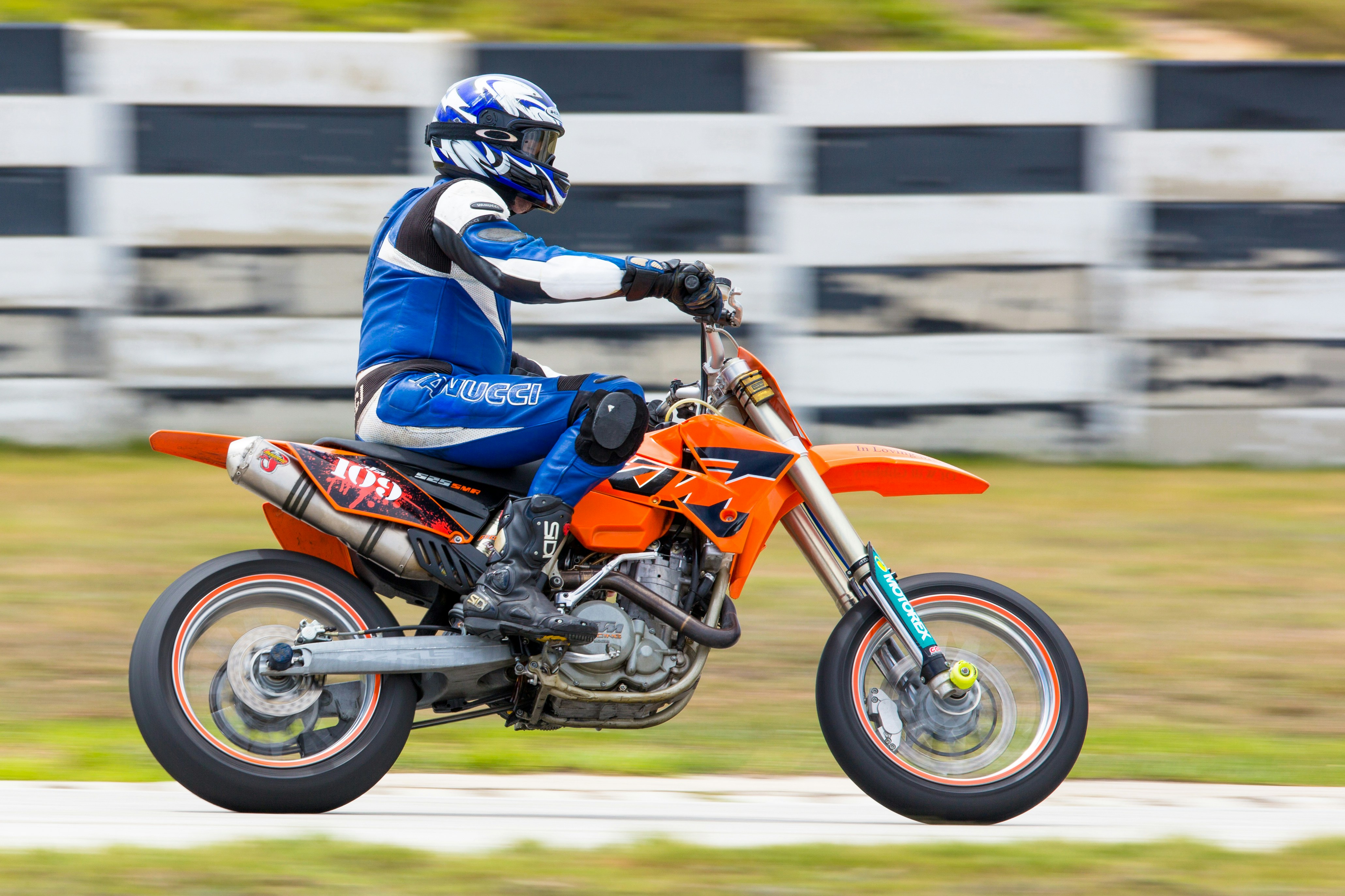 A person riding a motorcycle on a track photo – Free Helmet Image on ...