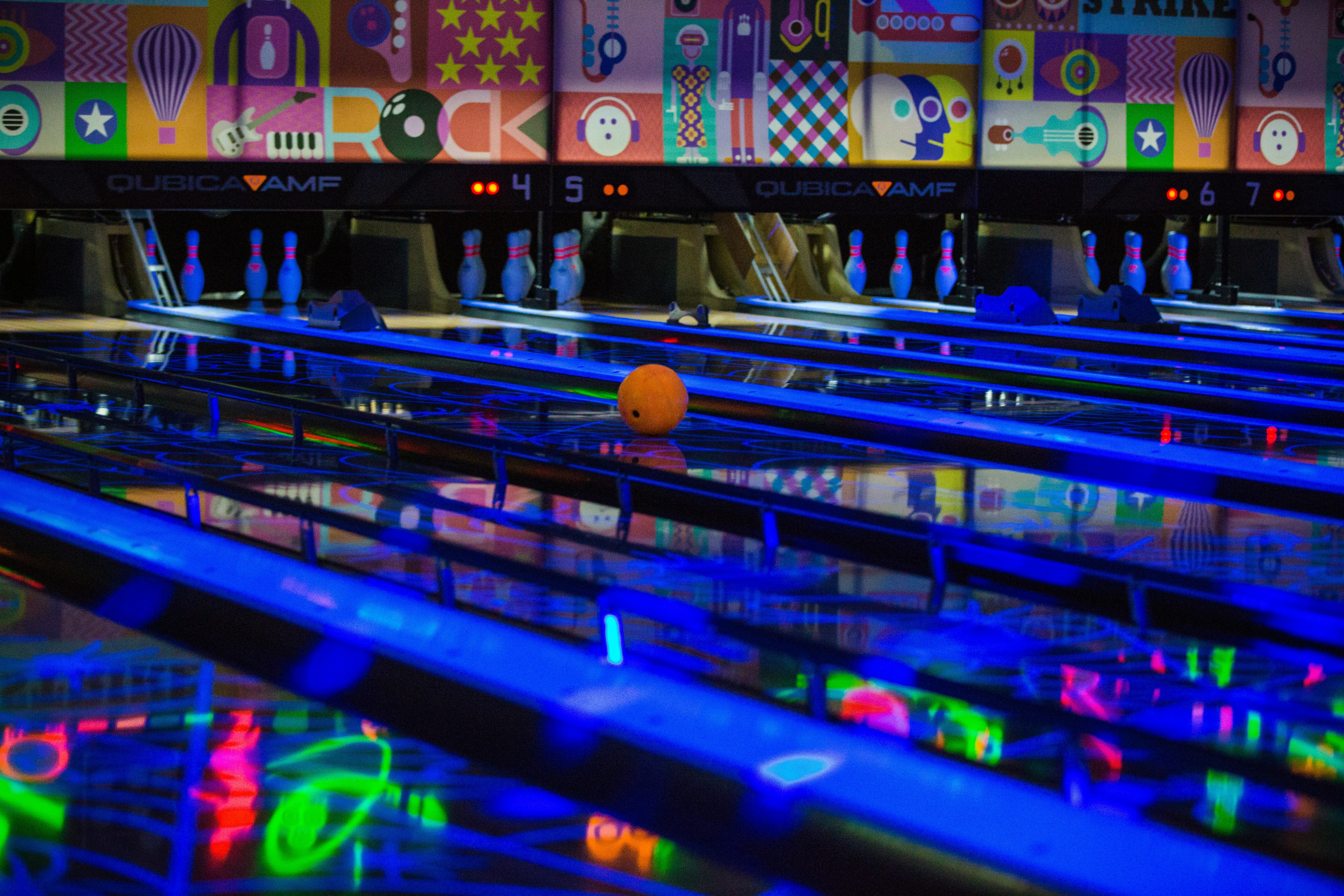 A bowling alley filled with neon bowling balls photo – Free Bowling ...