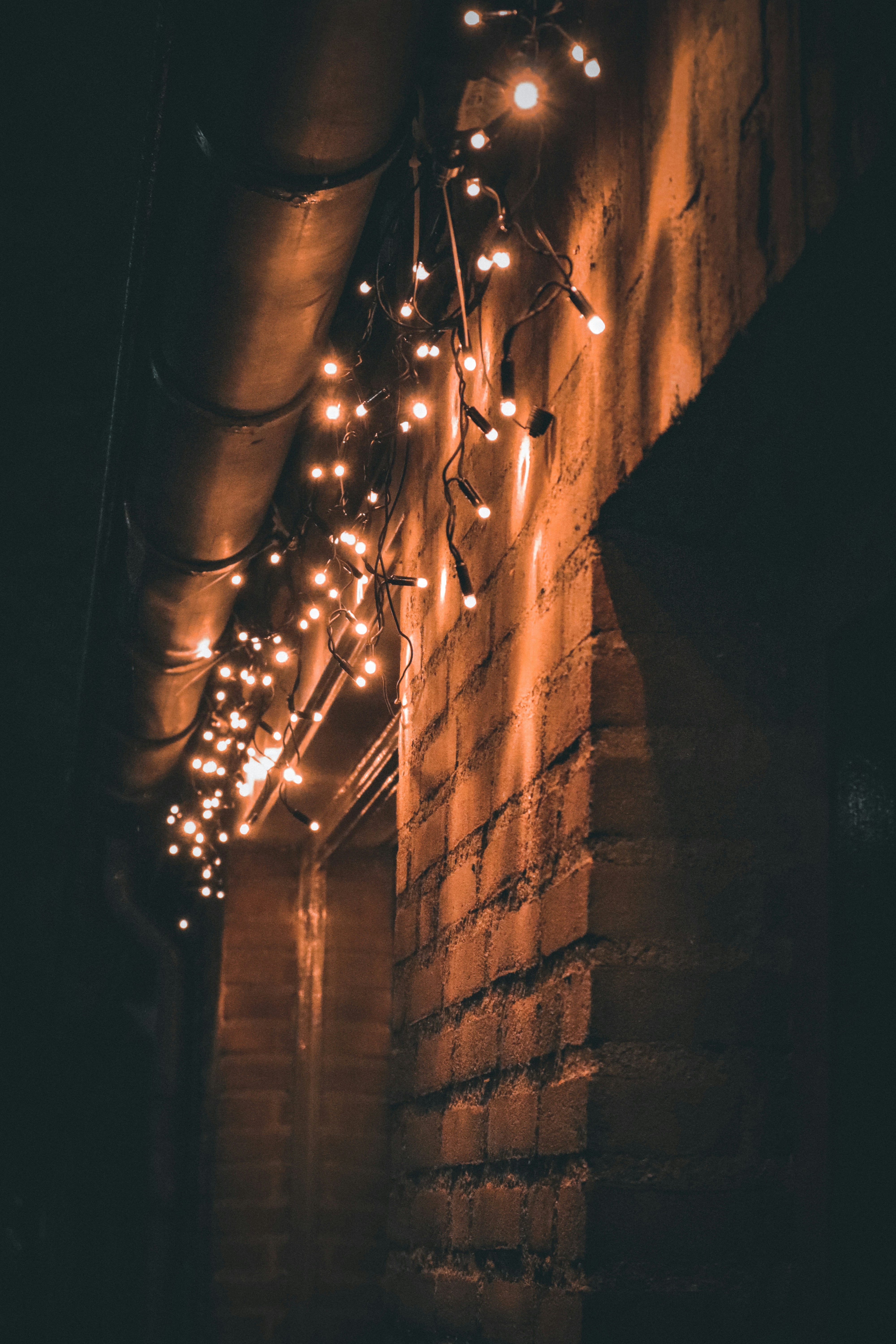 A brick wall with lights hanging from it photo – Free Brickstone Image ...
