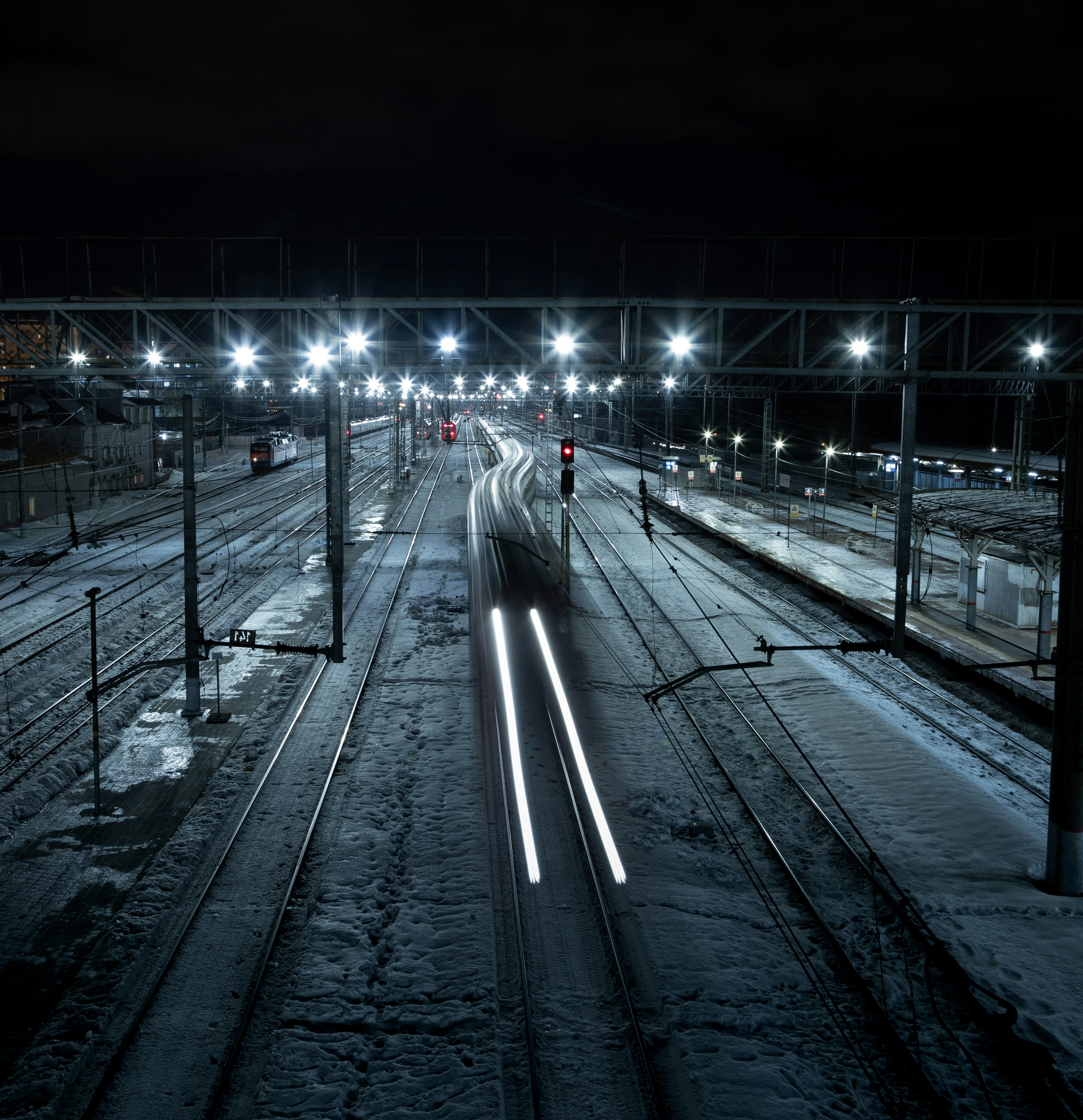 A train traveling down train tracks at night photo – Free Train station ...