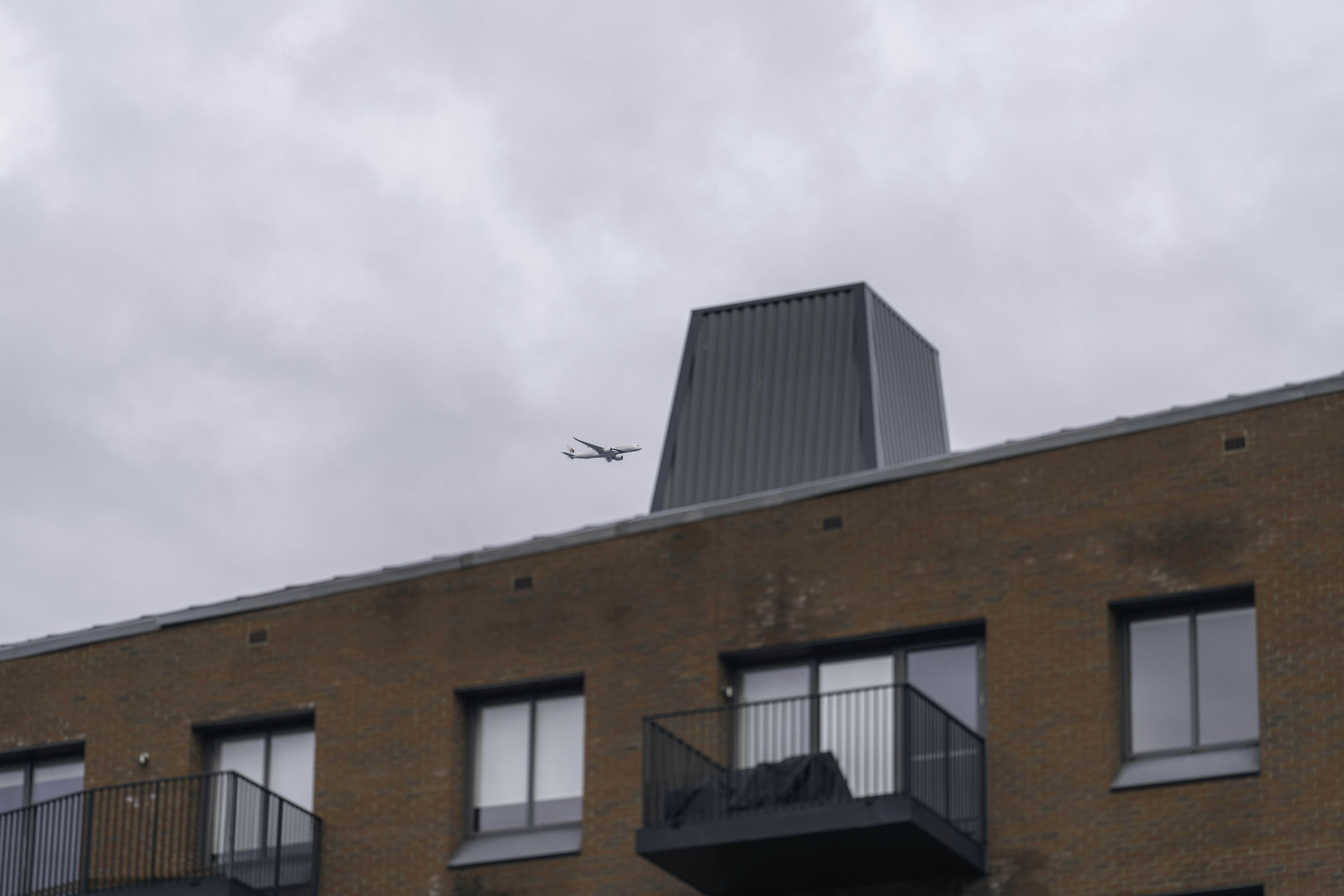 Drone Silhouette Over a Brick Apartment Bloc