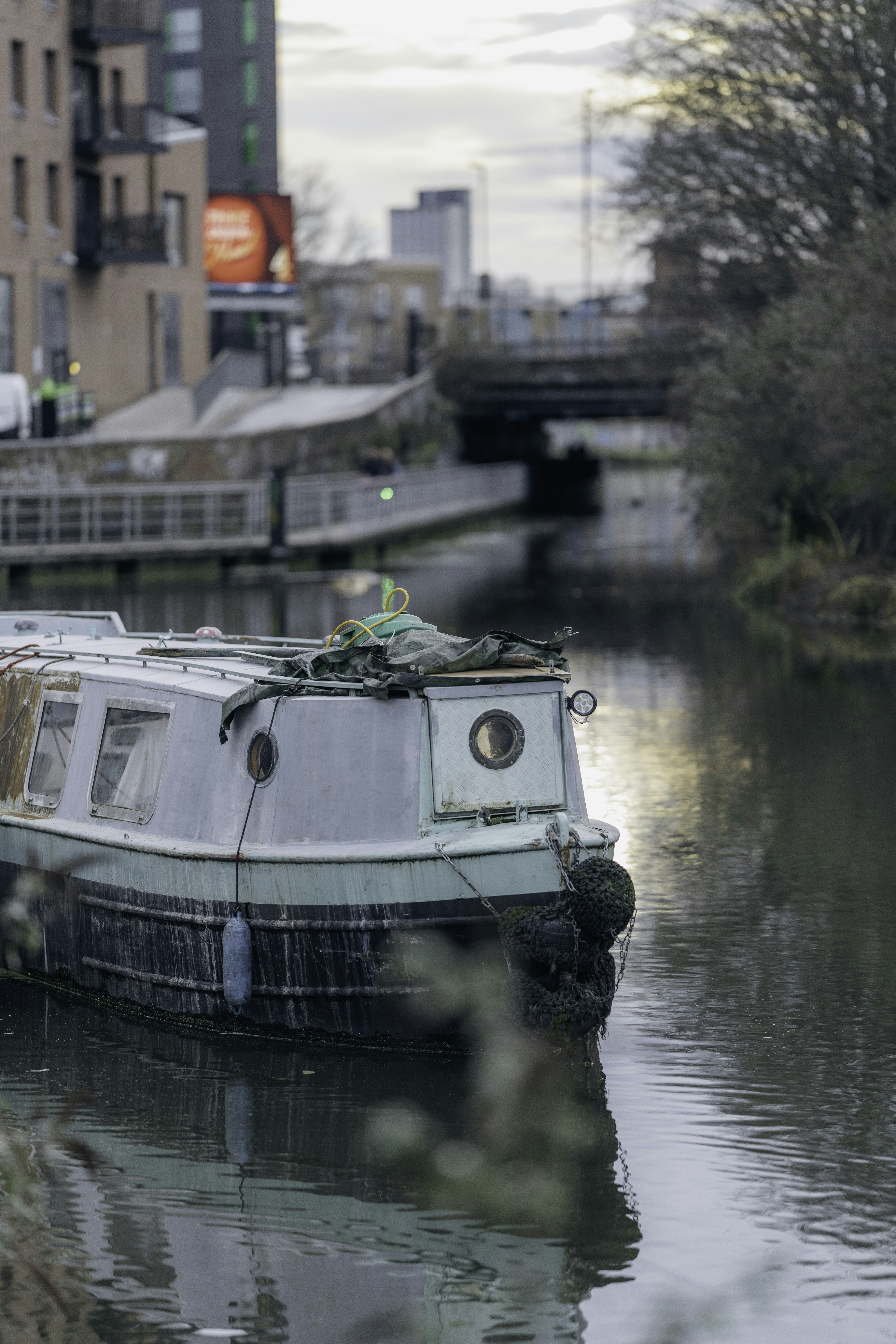A white boat floating down a river next to tall buildings photo – Free ...