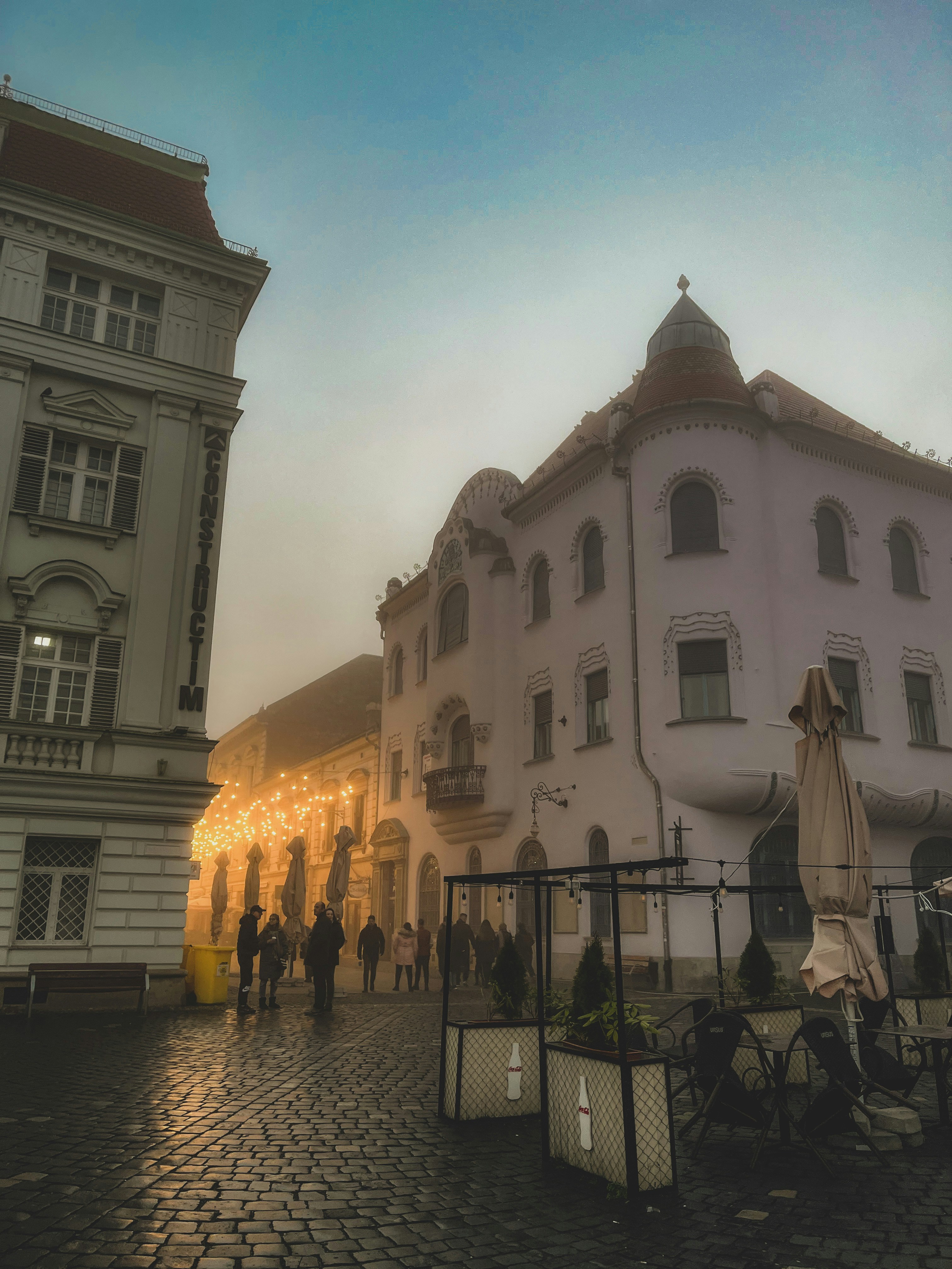 a group of people standing outside of a white building photo – Free ...