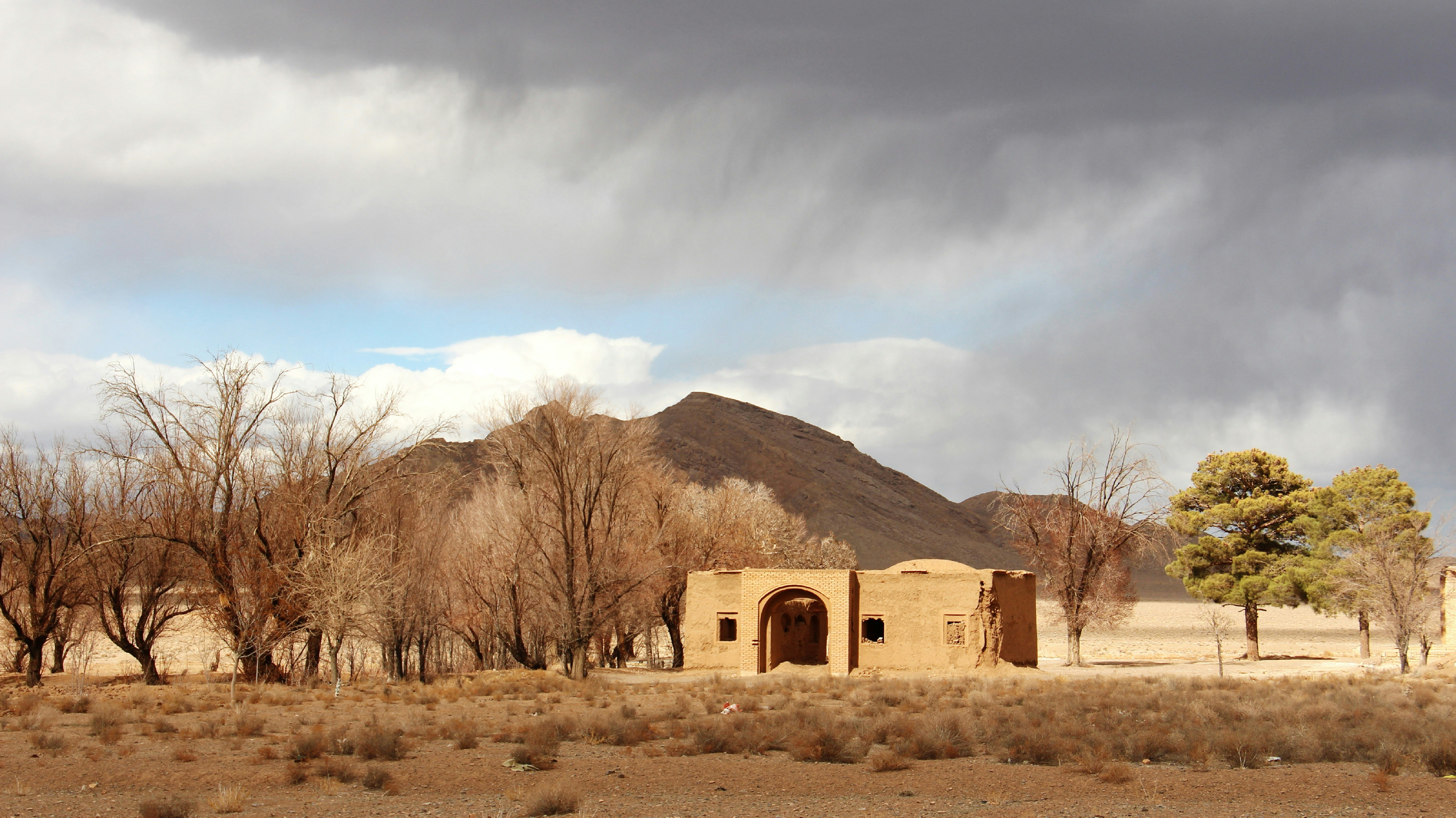 Isolated Adobe House Beneath a Looming Desert Storm