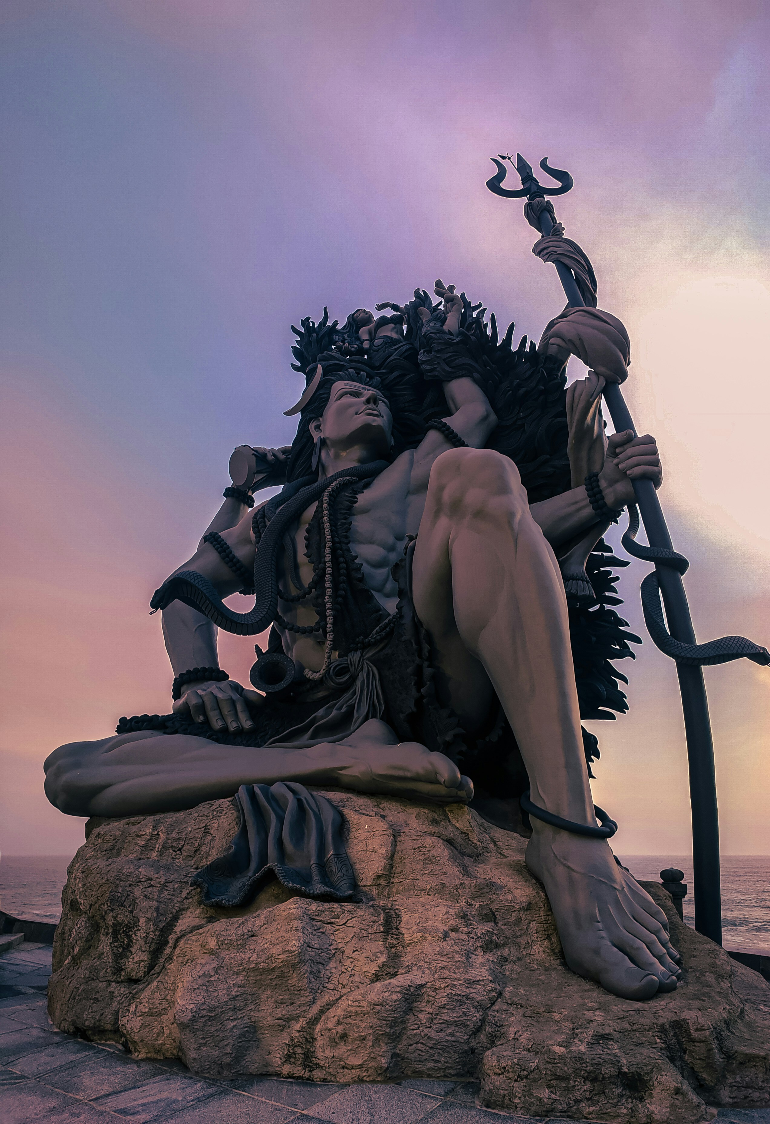 Une statue d’un homme assis au sommet d’un rocher photo – Photo ...