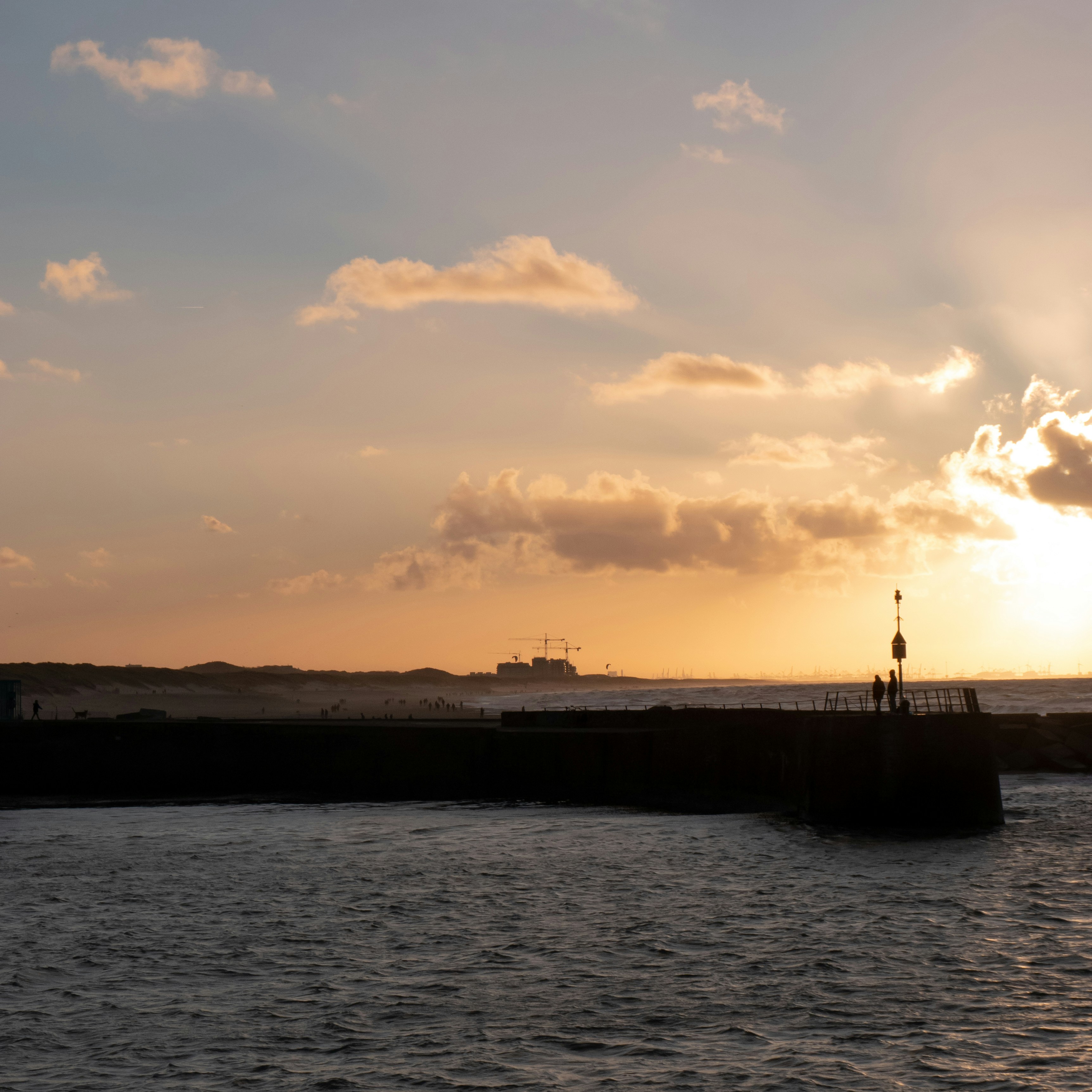 Breakwater Sunset: Silhouettes Along a Quiet Horizon