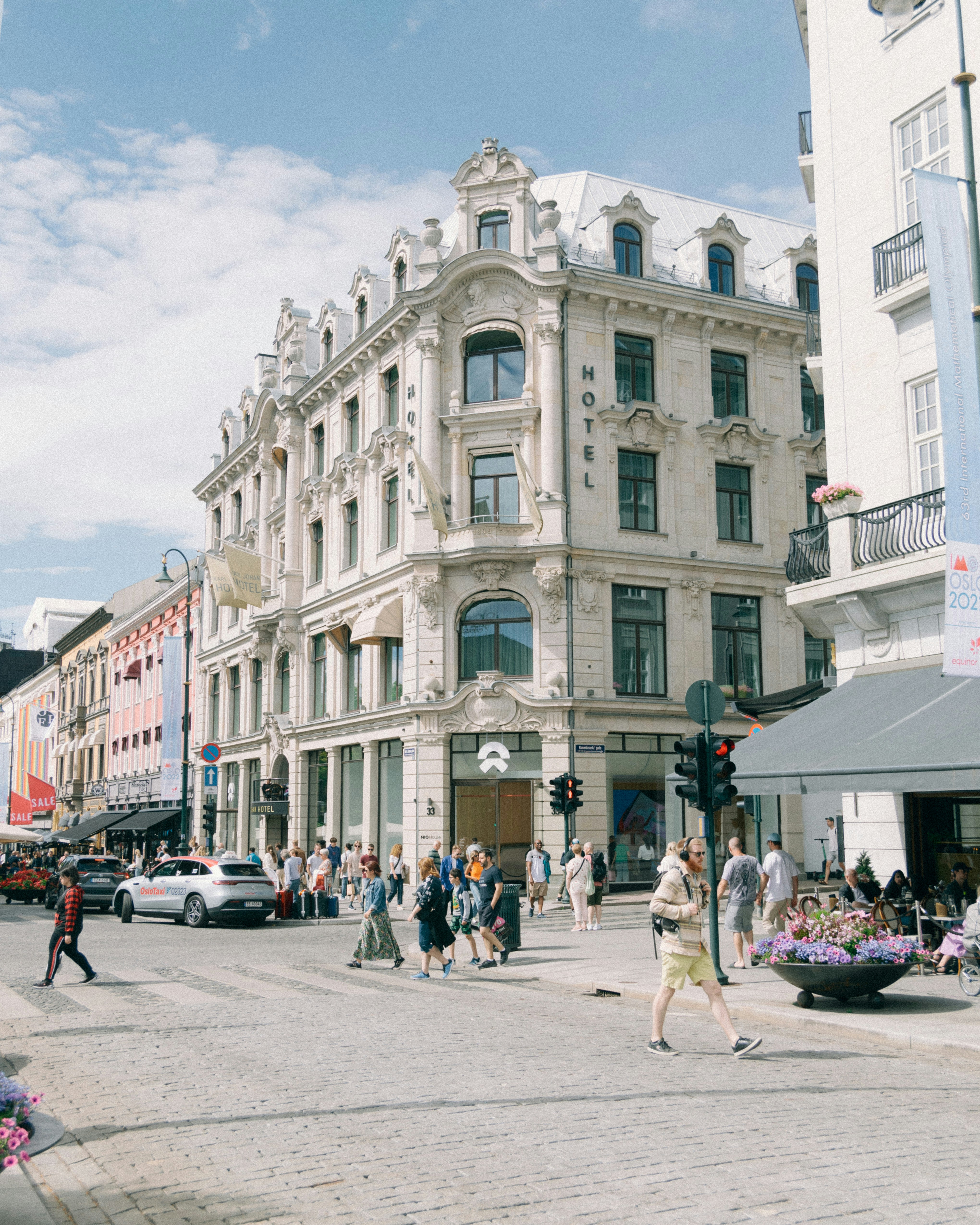 A group of people walking down a street next to tall buildings photo ...