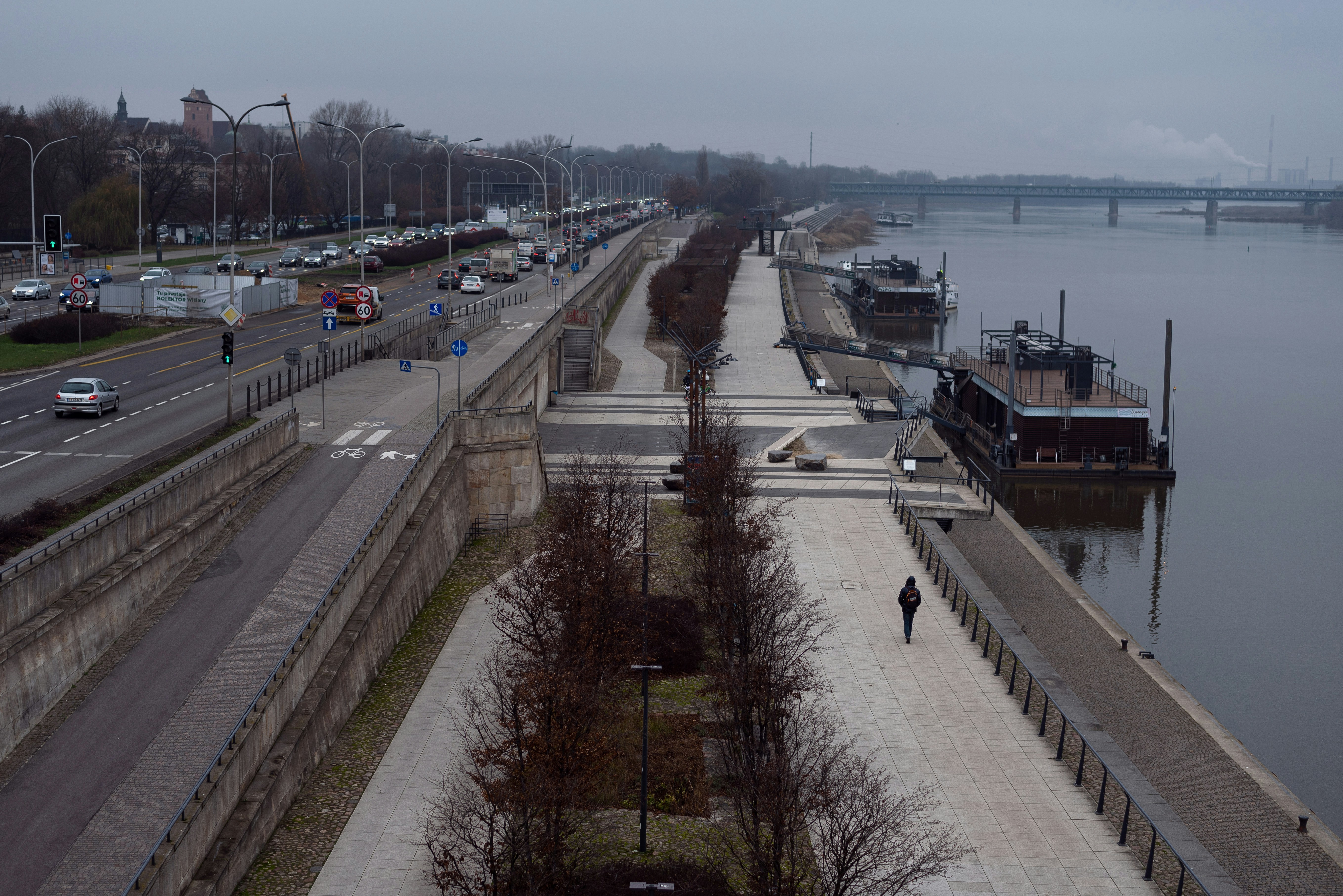 Grey Promenade by the River: A Lone Walker Tracing the Linear Banks