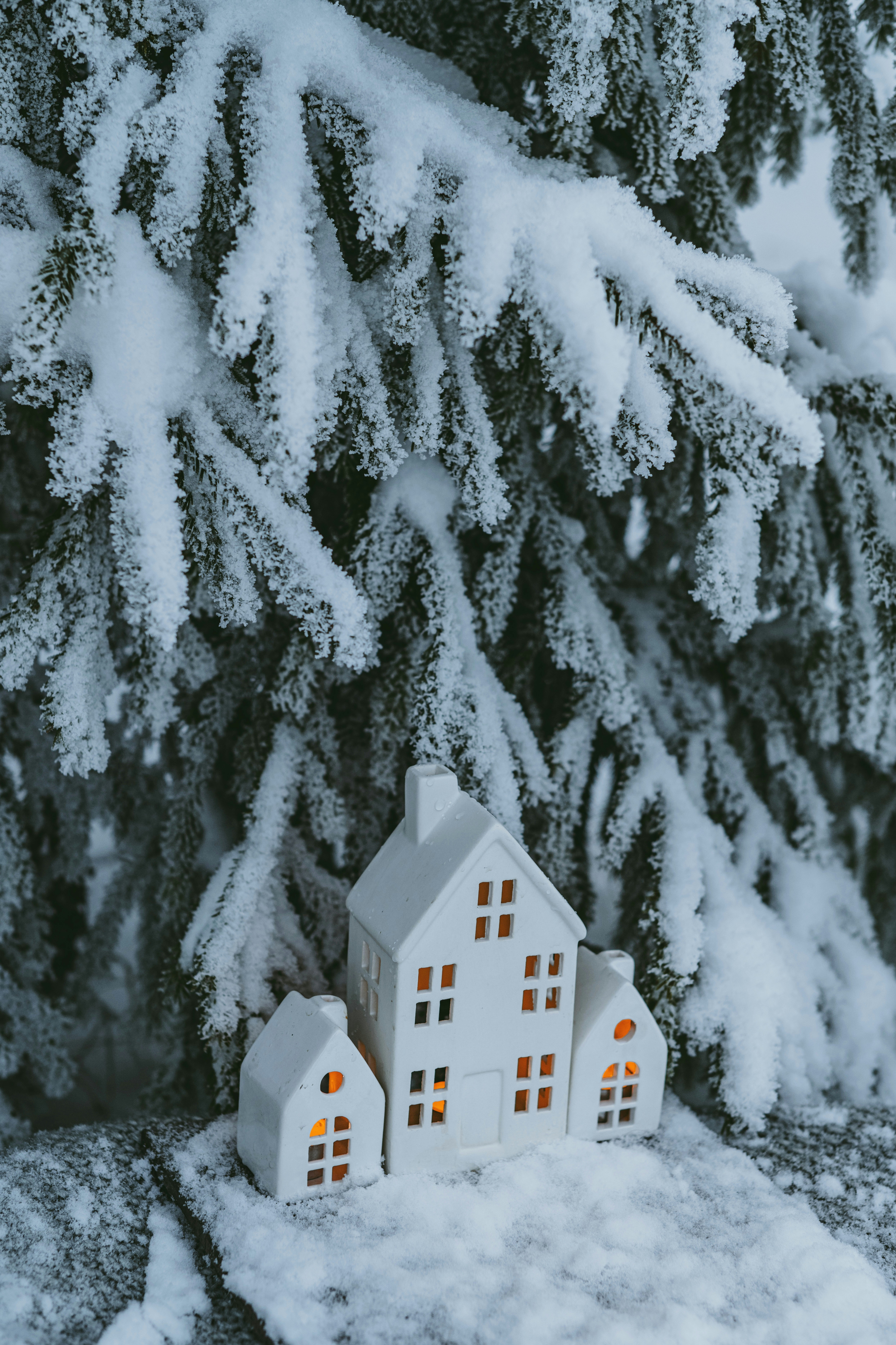 a small white house sitting on top of snow covered ground