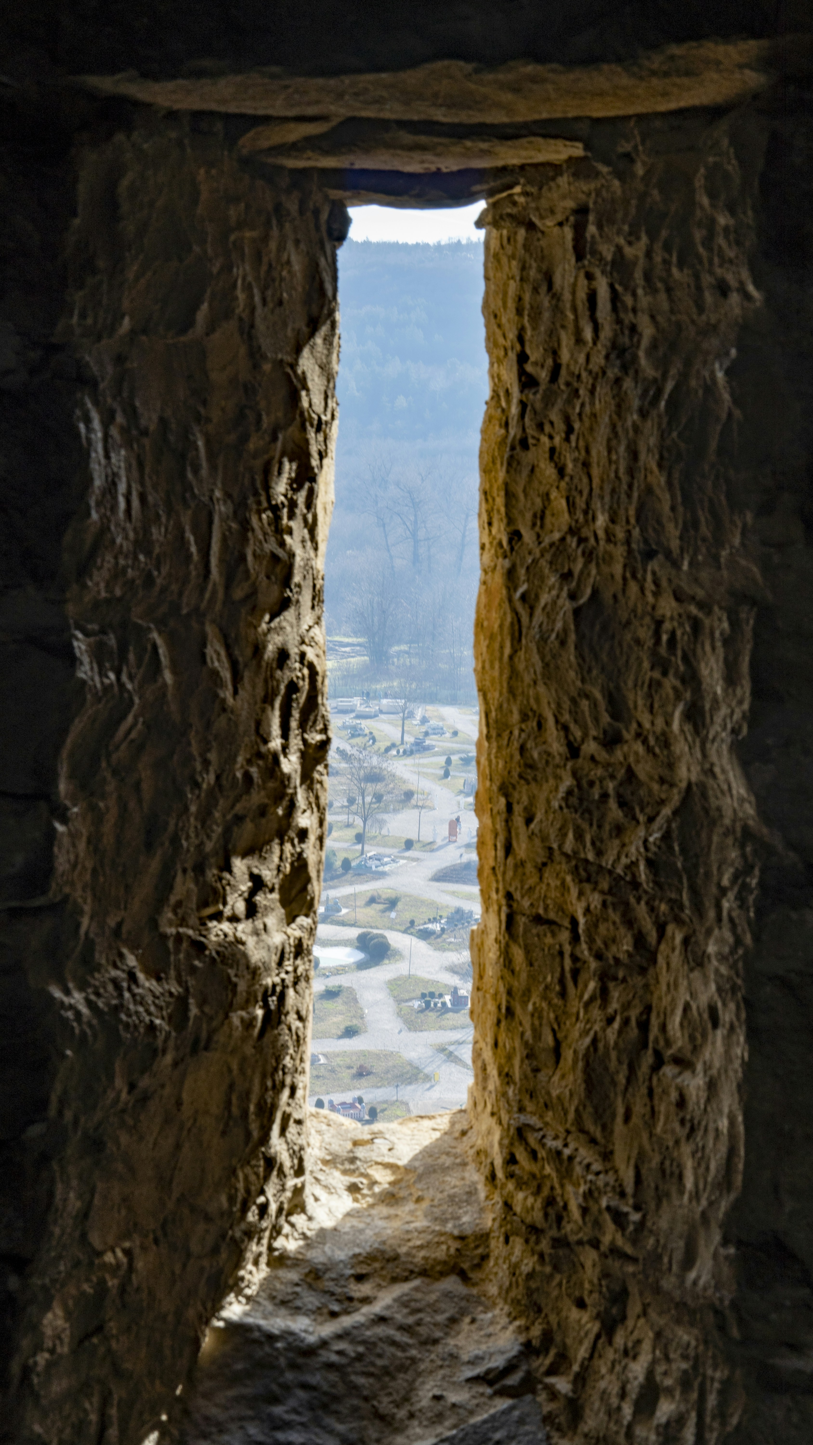 Une fenêtre ouverte dans un mur de pierre avec vue sur une ville en ...