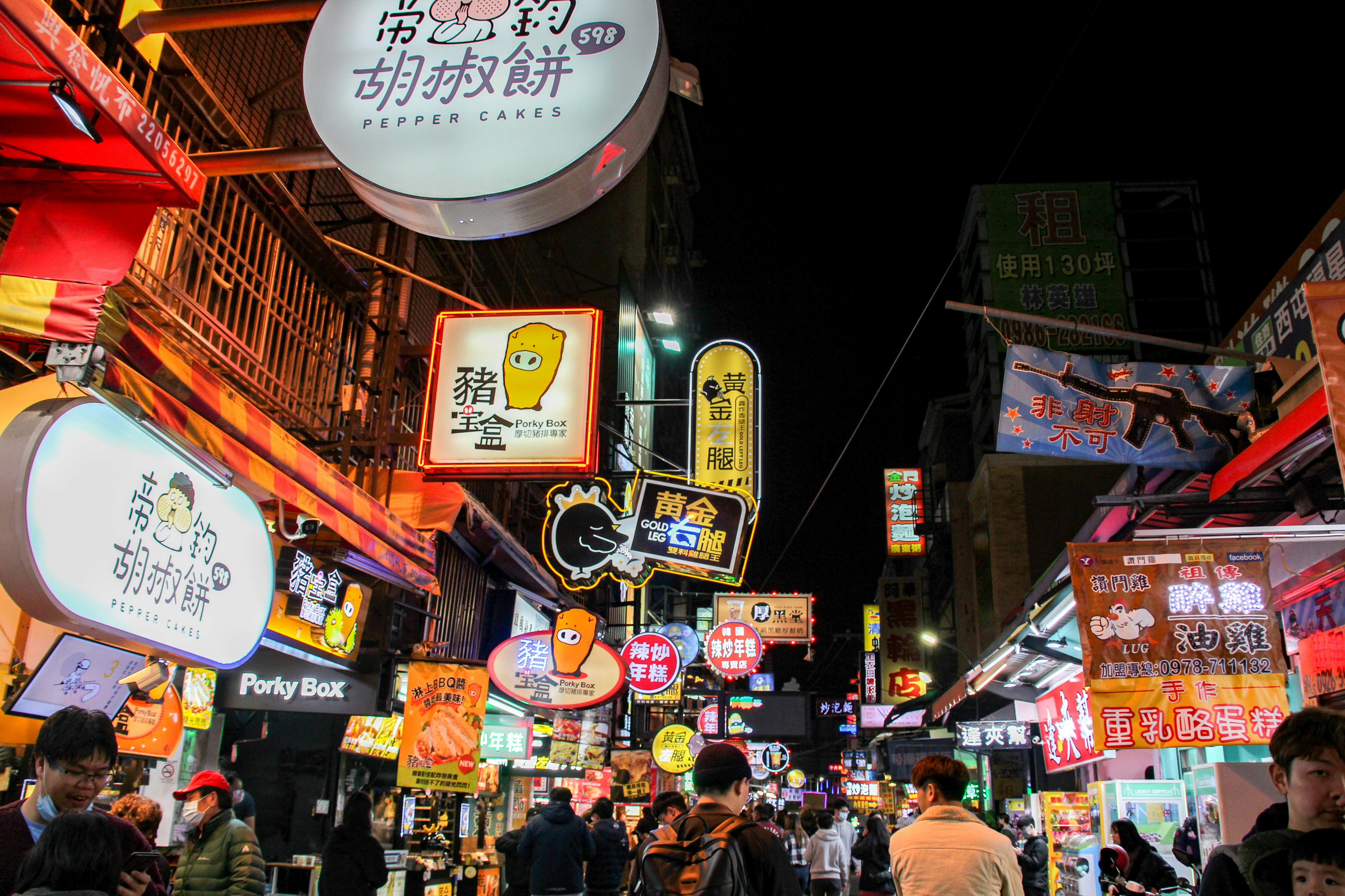 A group of people walking down a street at night photo – Free Night ...