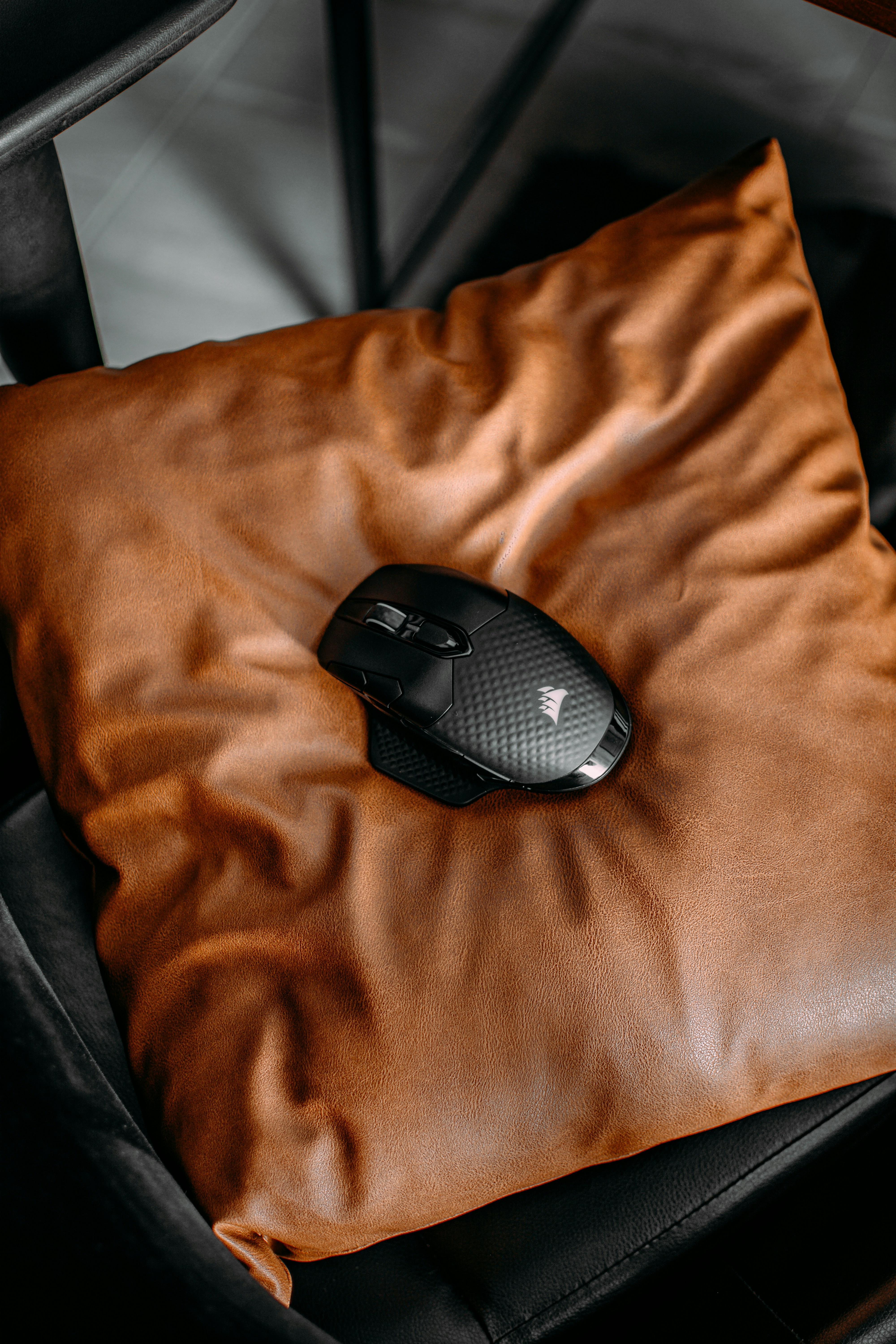 A computer mouse sitting on top of a brown pillow photo – Free Cushion ...