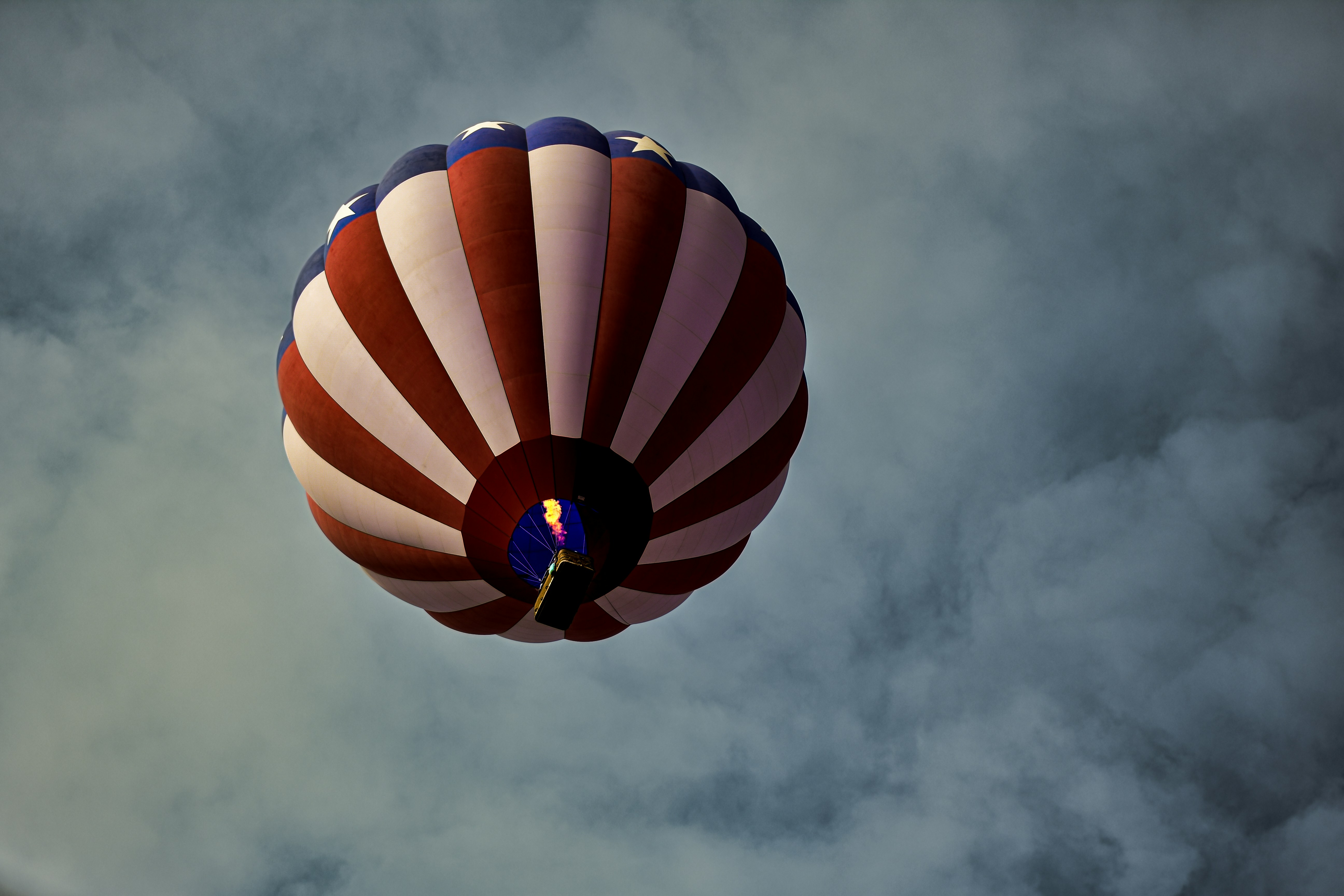 Floating Beacon: A Striped Balloon Against a Clouded Sky