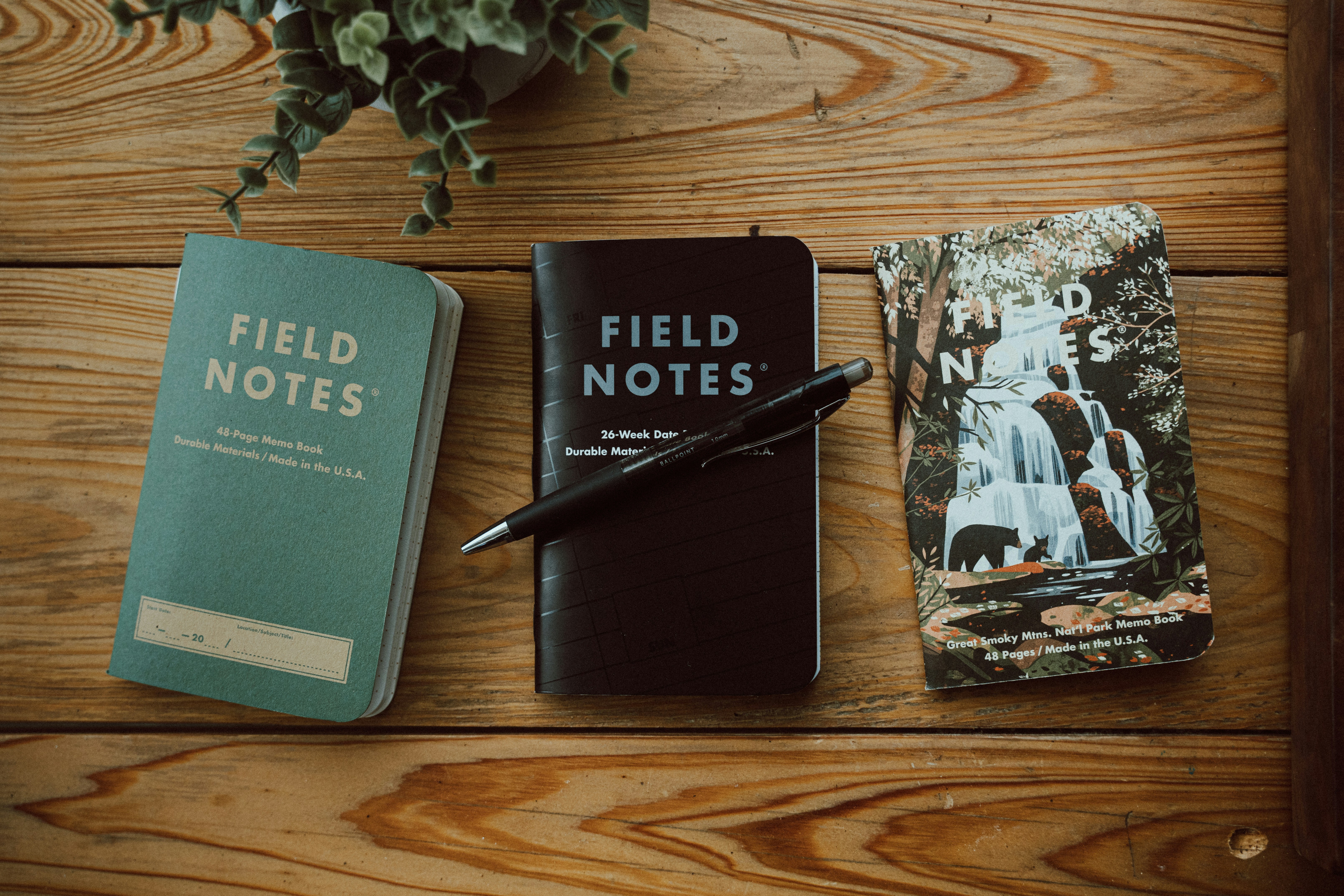A notebook, pen, and notebook sitting on a wooden table photo – Free ...