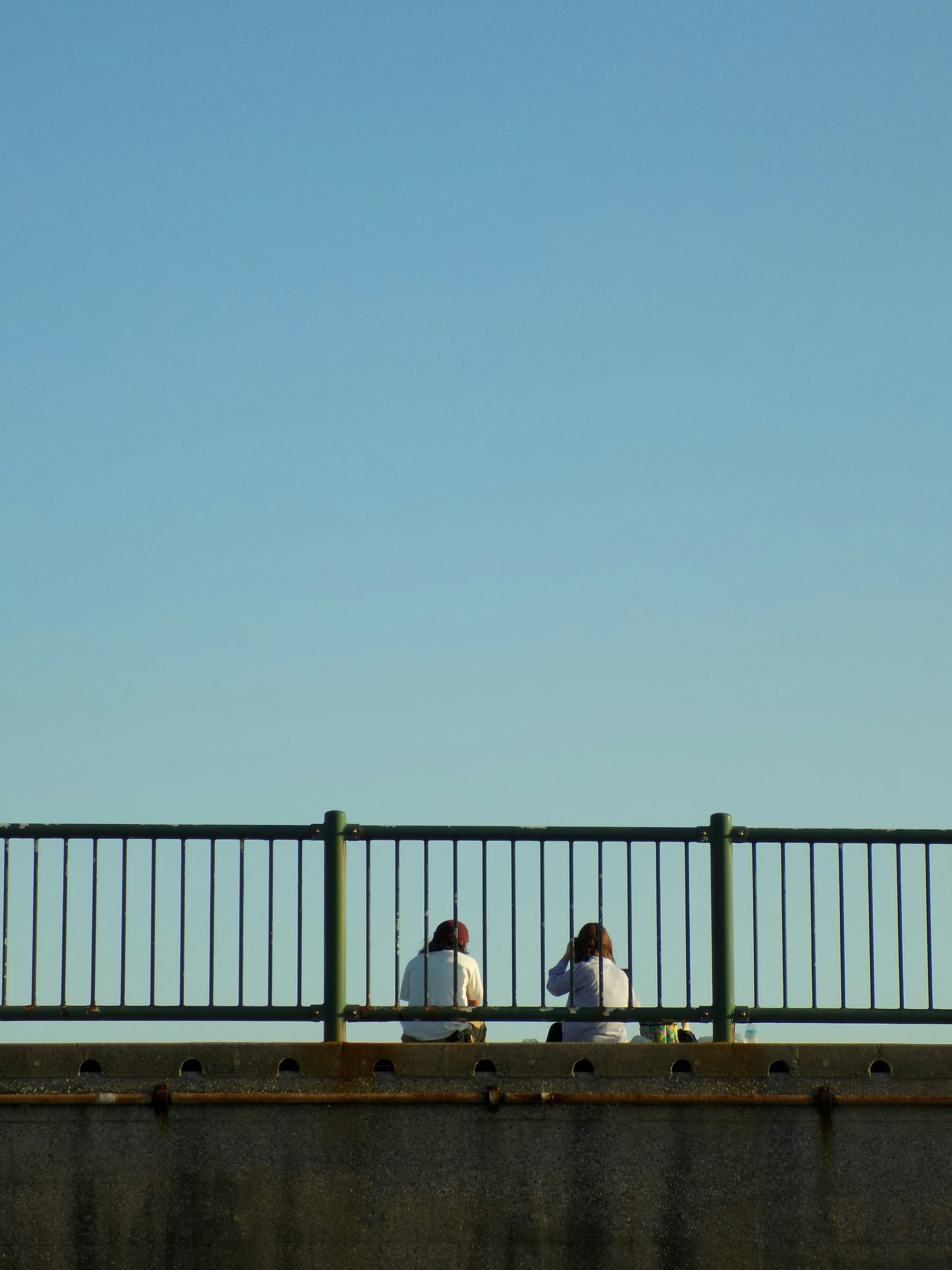 A couple of people sitting on top of a bridge photo – Free Japan Image ...