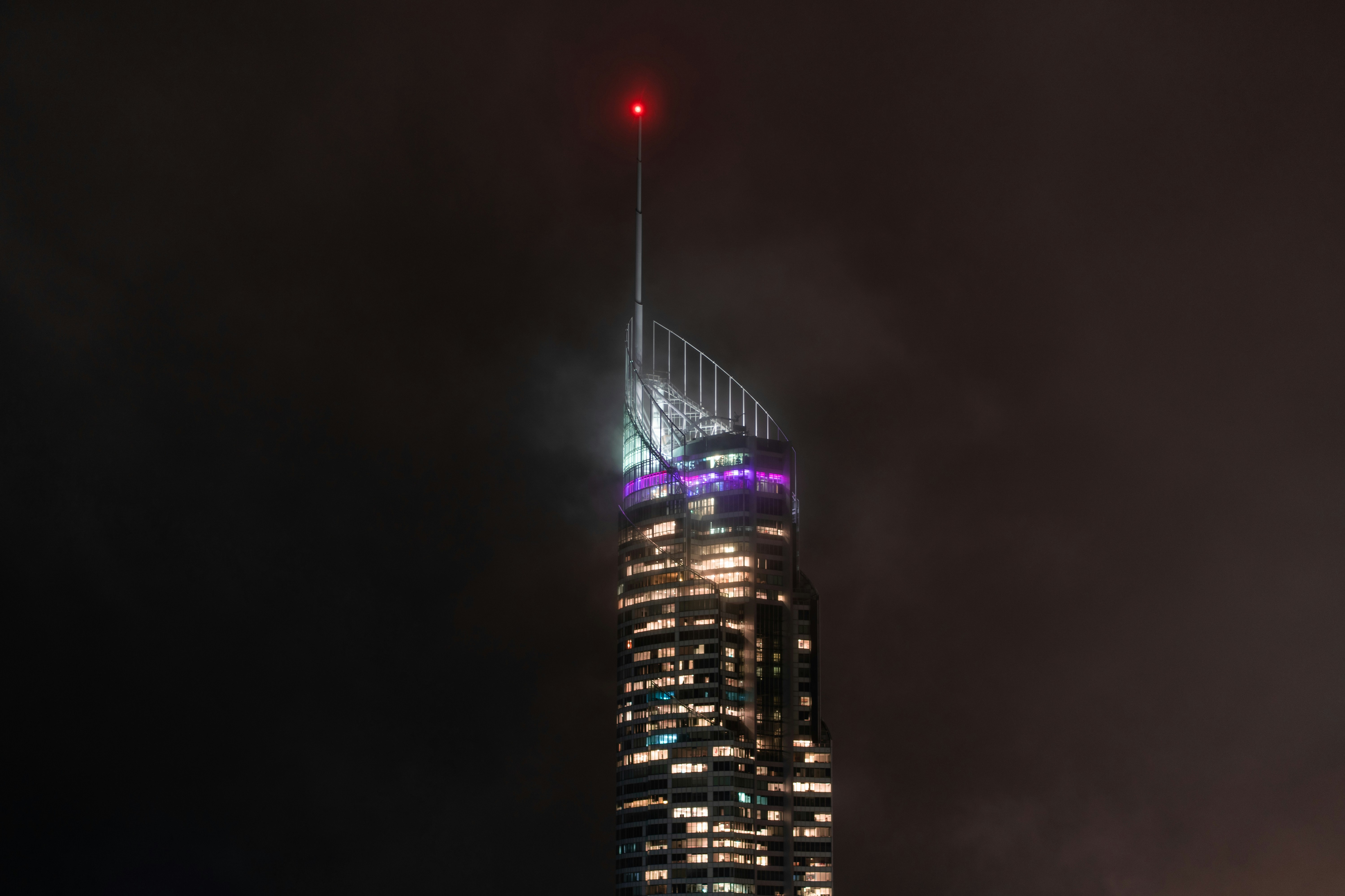 A tall building with a red light on top of it photo – Free City Image ...