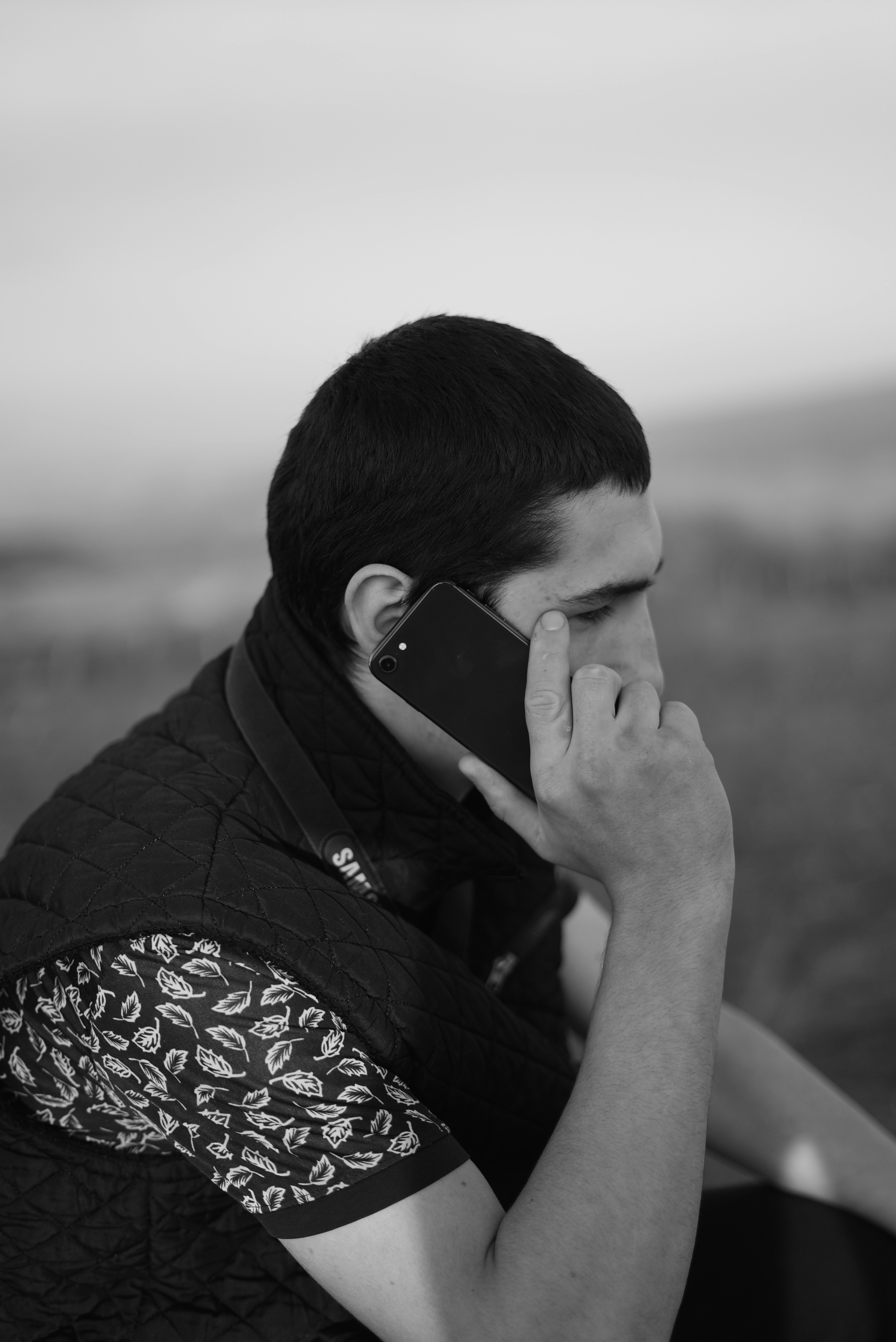 A man sitting down talking on a cell phone photo – Free Photography ...