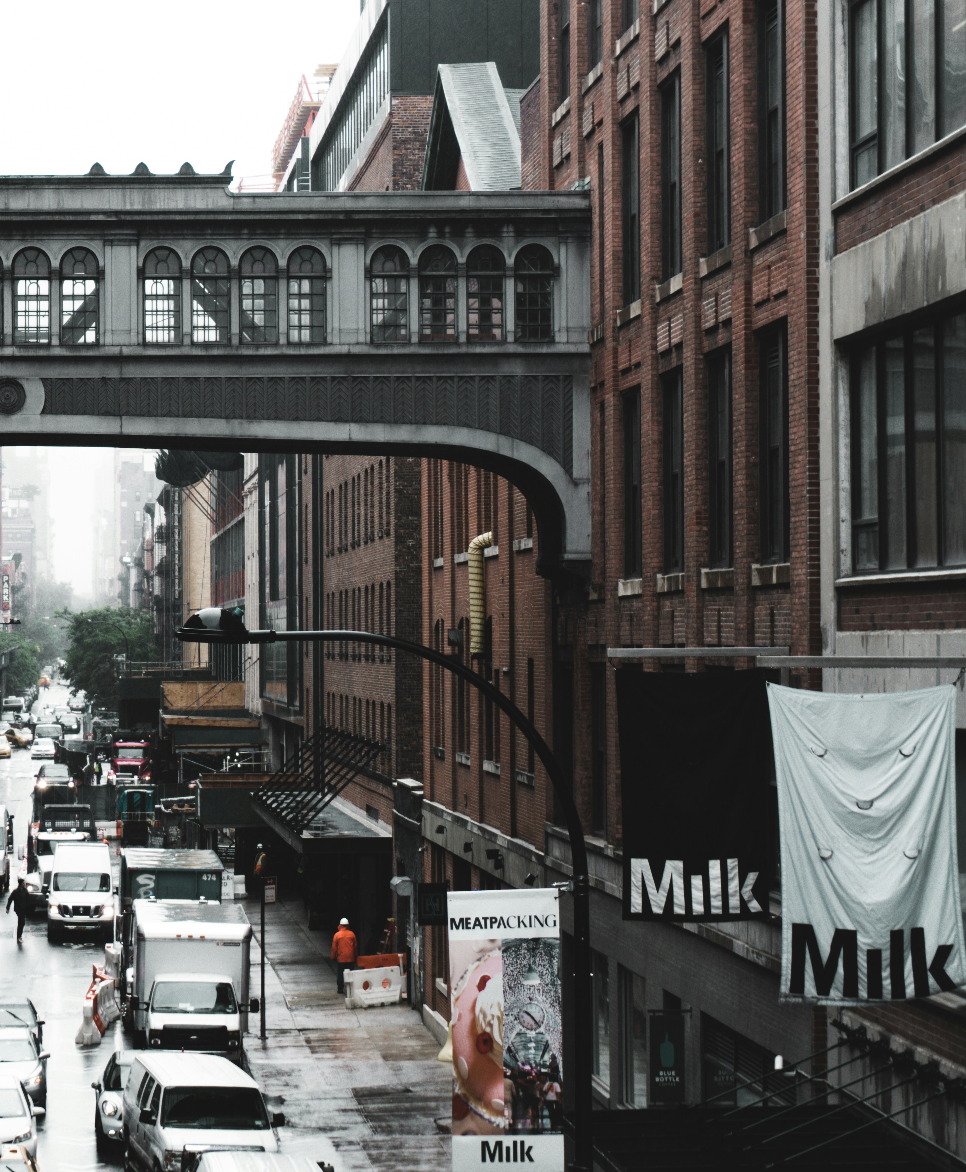 Archways, Rain, and Milk: A Meatpacking District Street Framed by Brick Skyline