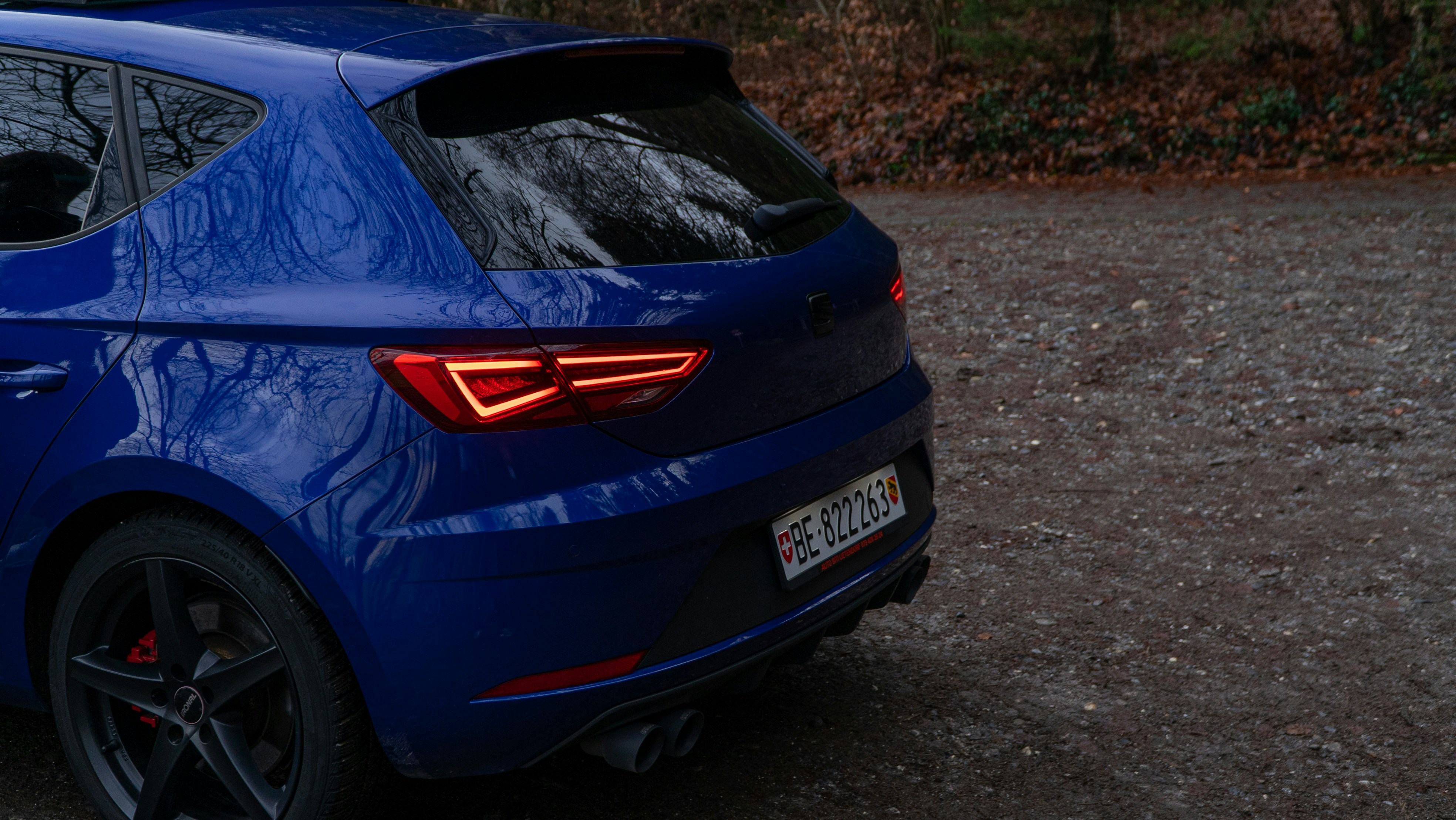 a blue car parked on a gravel road
