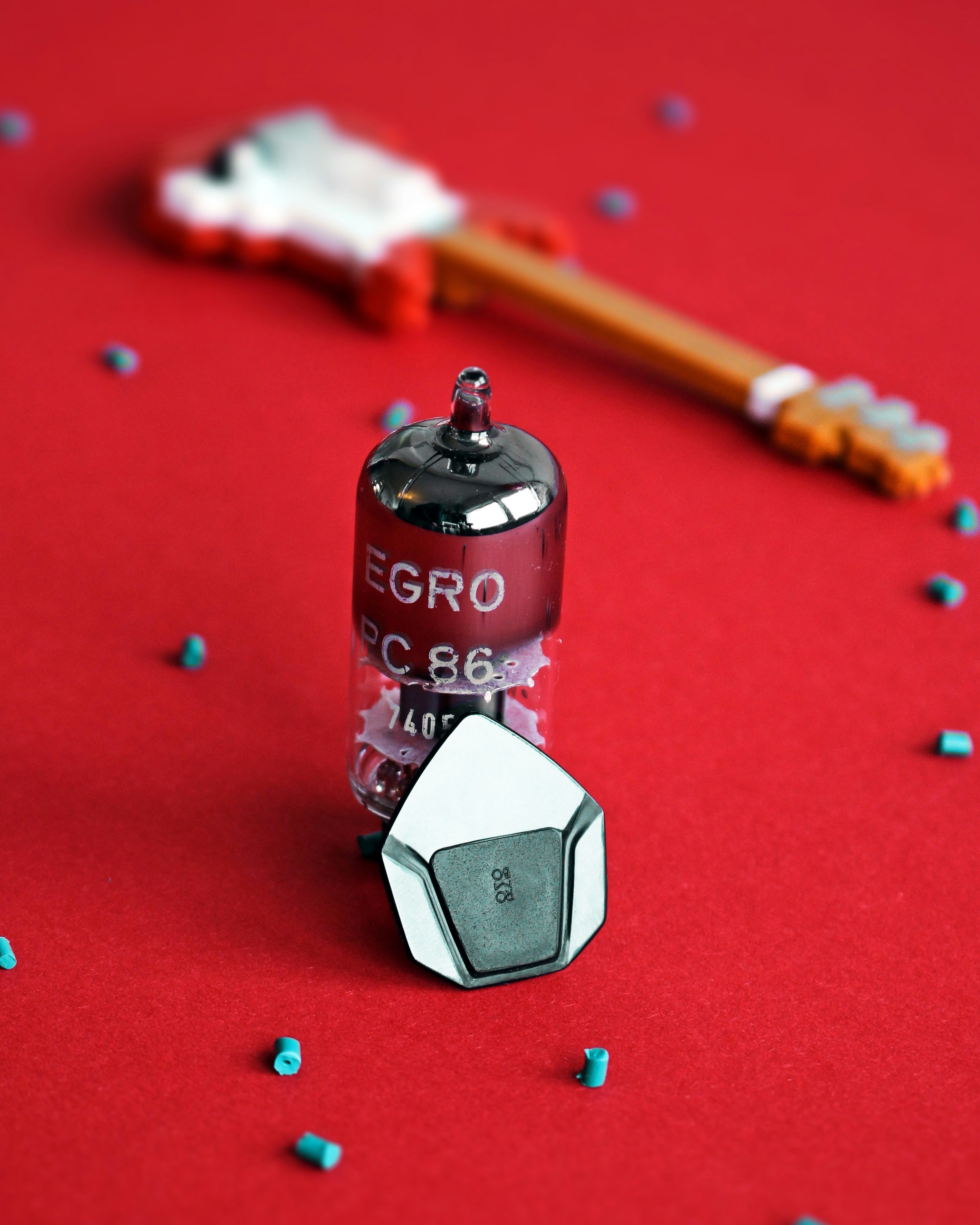A close up of a small metal object on a red surface photo – Free Guitar ...