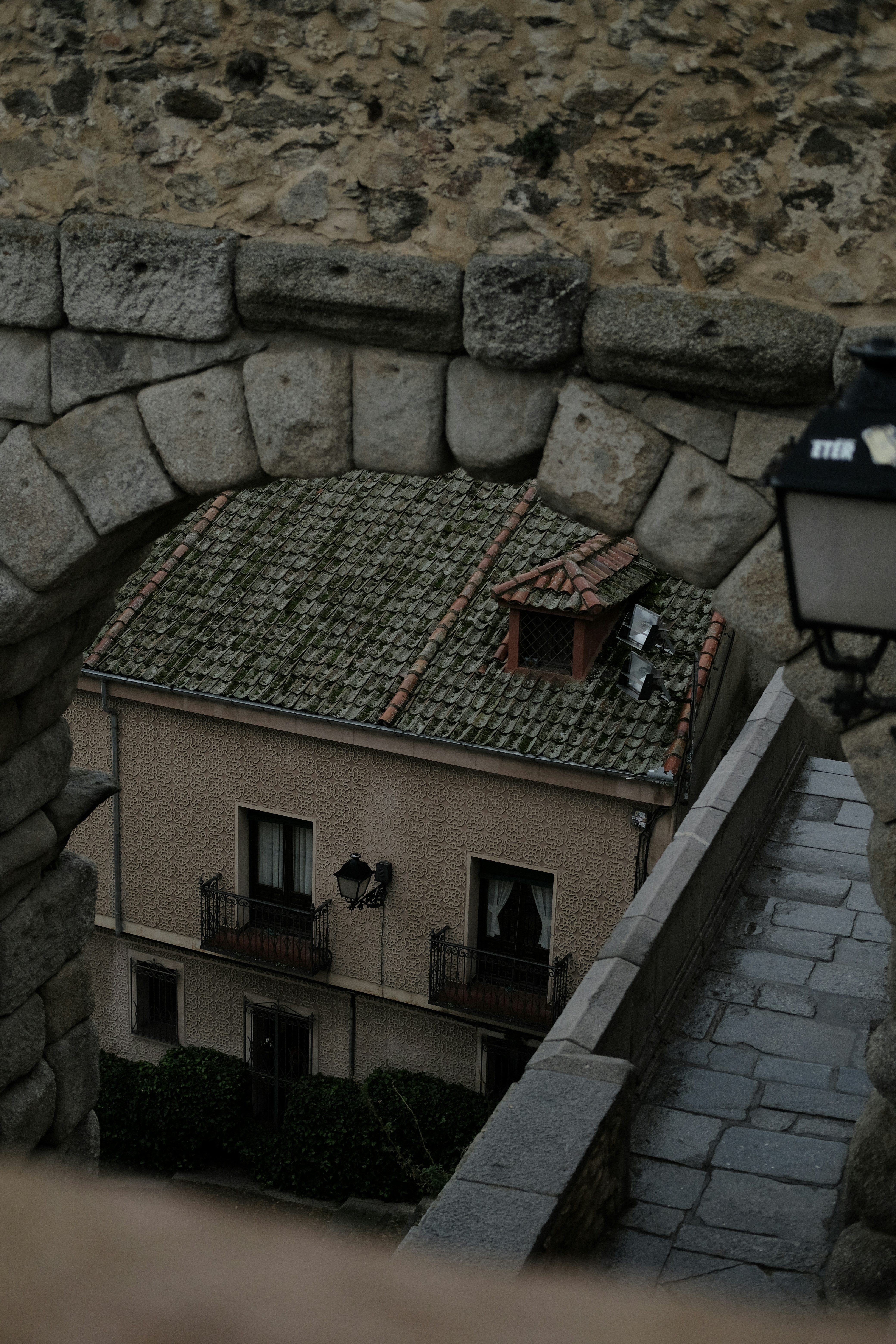 Stone Arch Framing a Rooftop Courtyard