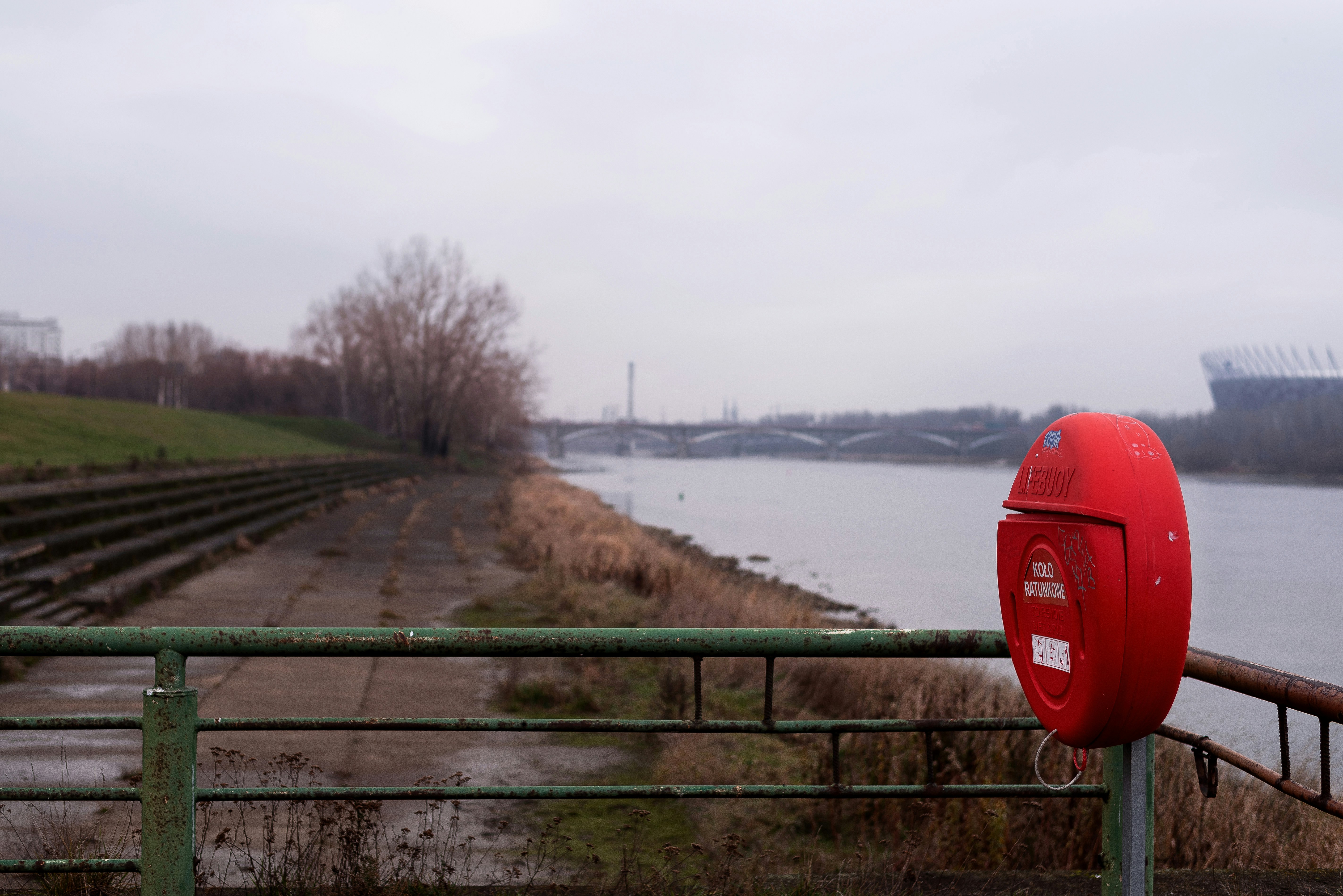 Red Life Preserver by the Riverbank: Quiet Industrial Sunset