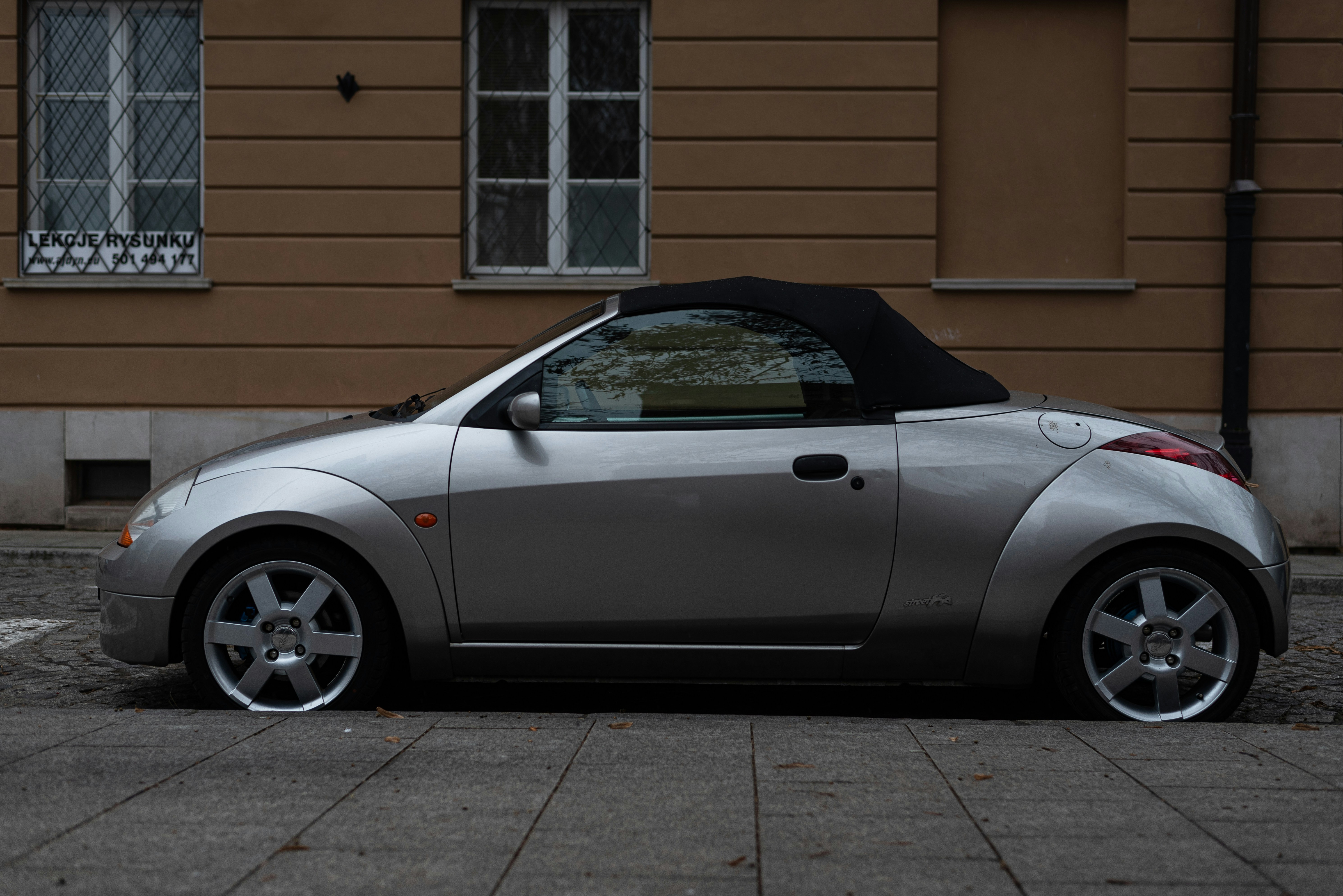 Silver Convertible Resting Along a City Street