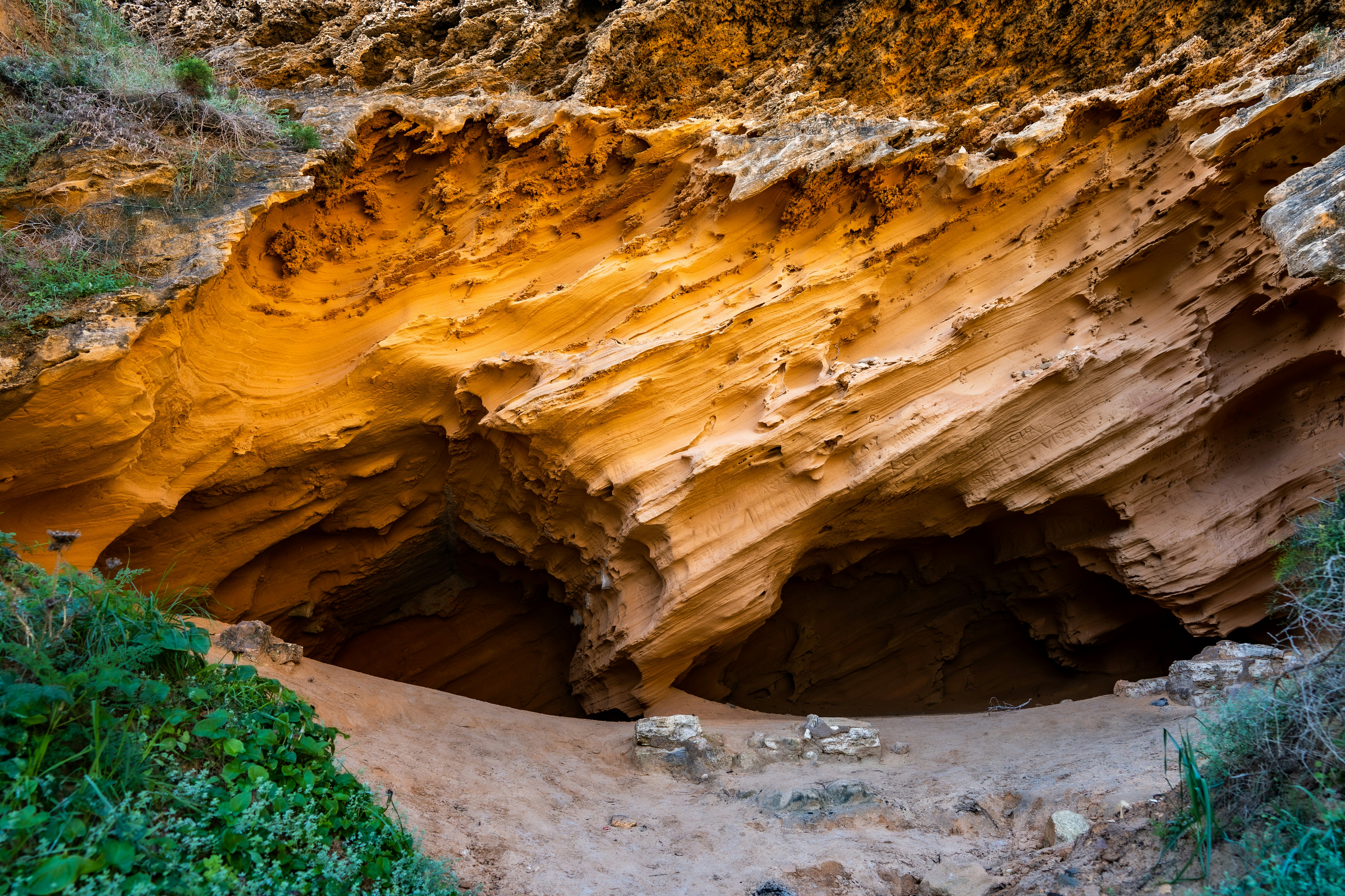 A cave with a dirt path leading into it photo – Free Cave Image on Unsplash