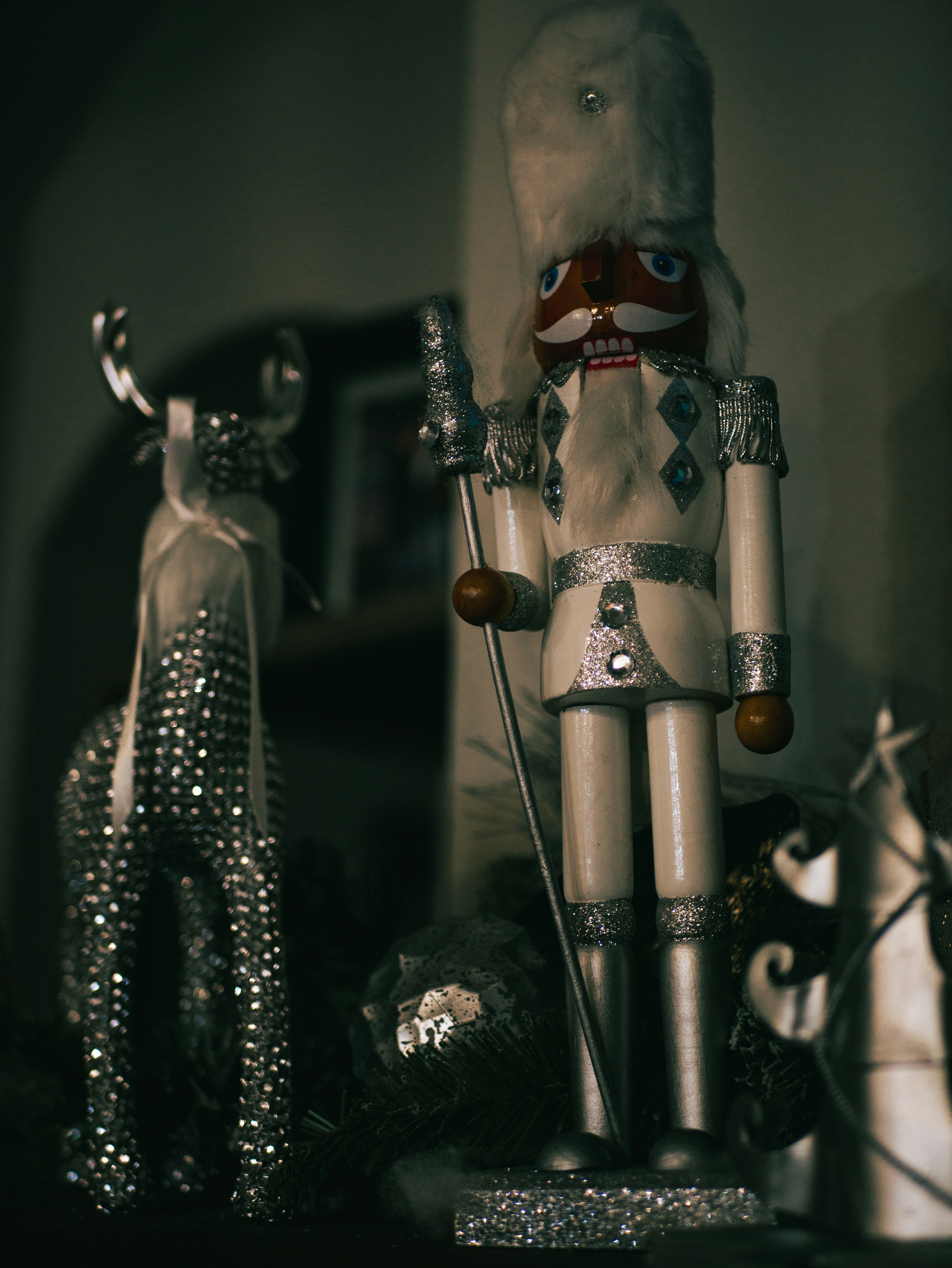 A glittering nutcracker stands proudly beside a sparkling reindeer, embodying festive spirit and seasonal charm.