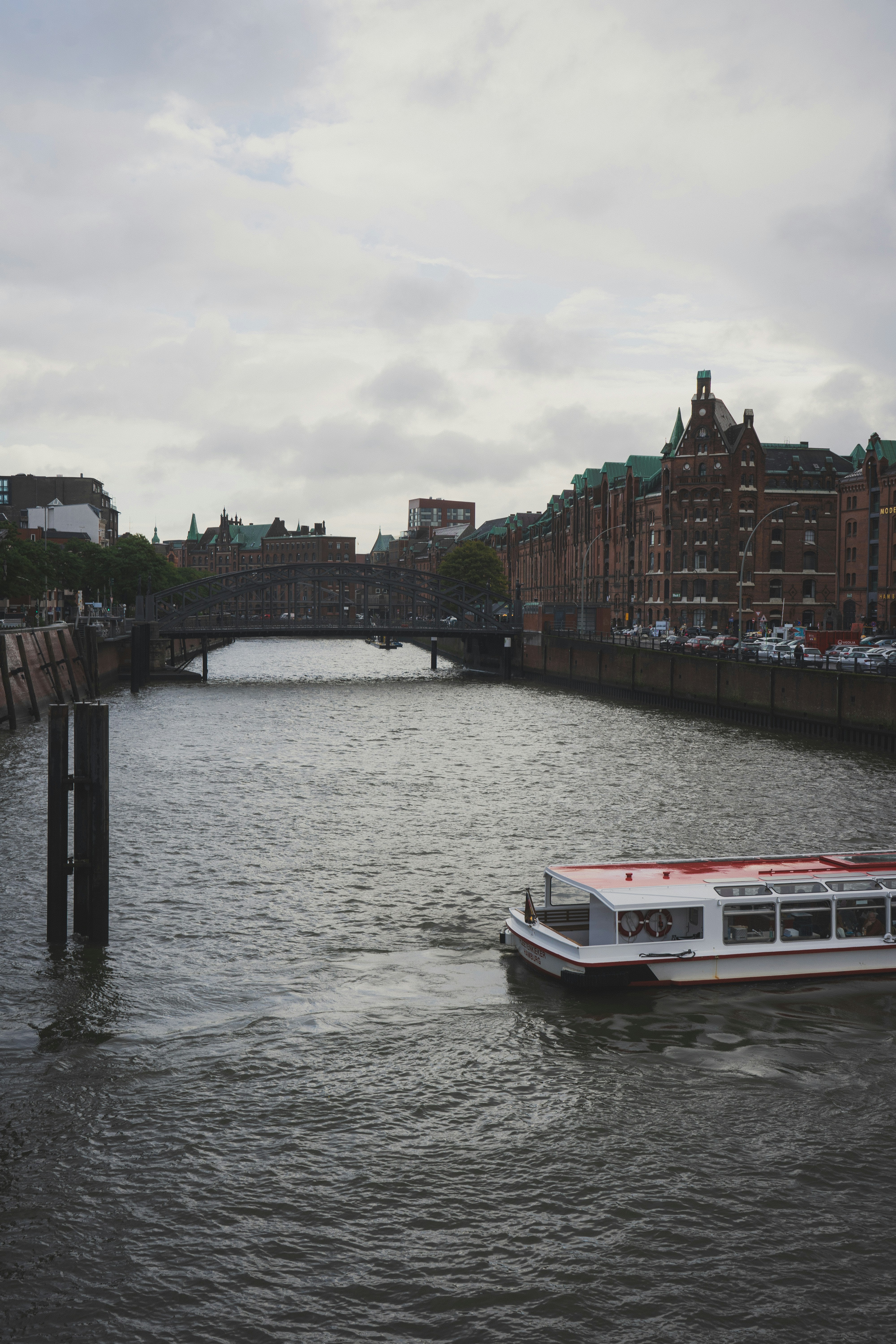 A boat traveling down a river next to tall buildings photo – Free ...