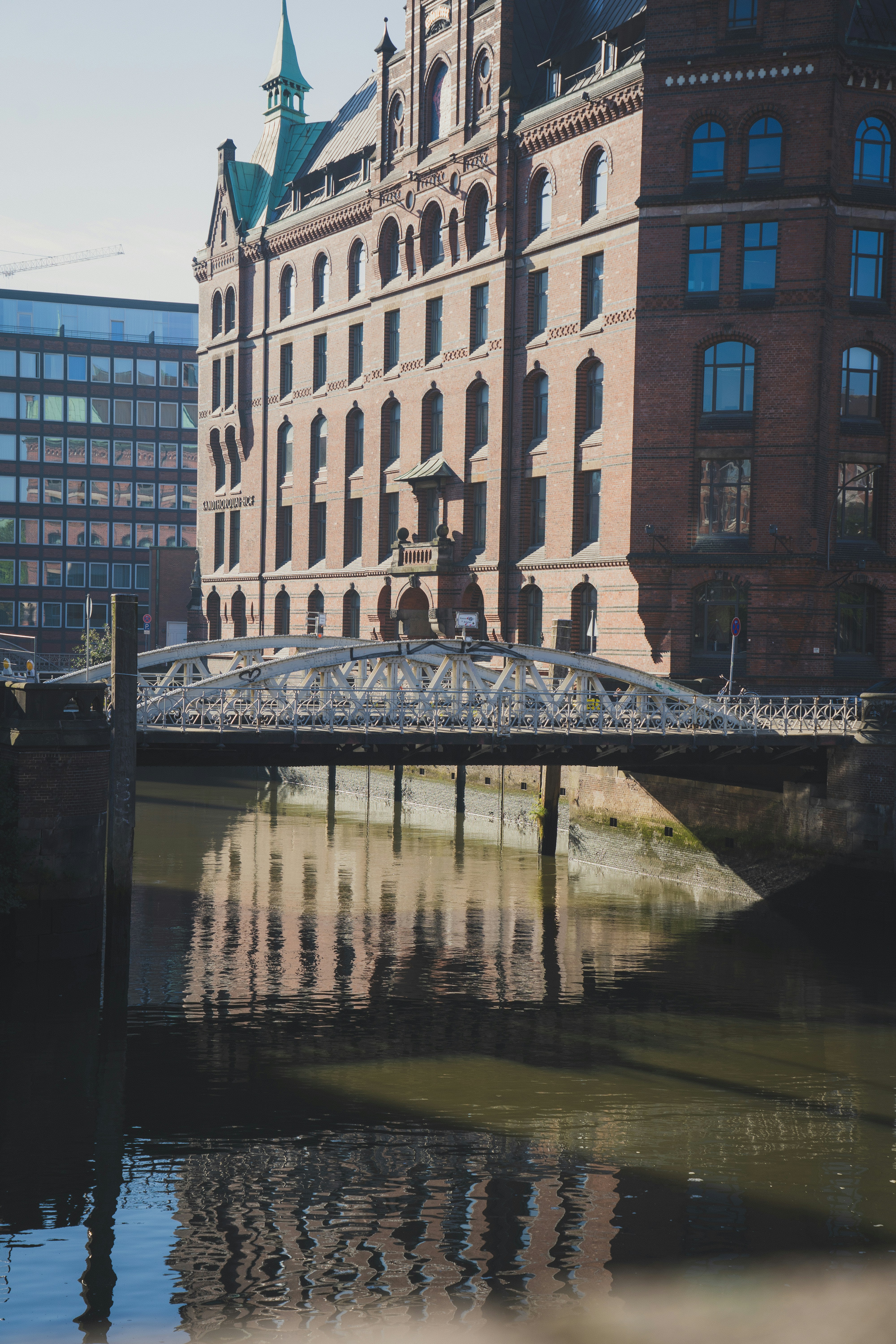 Foto Un puente sobre un cuerpo de agua frente a un gran edificio – Imagen Hamburgo-Mitte gratis ...