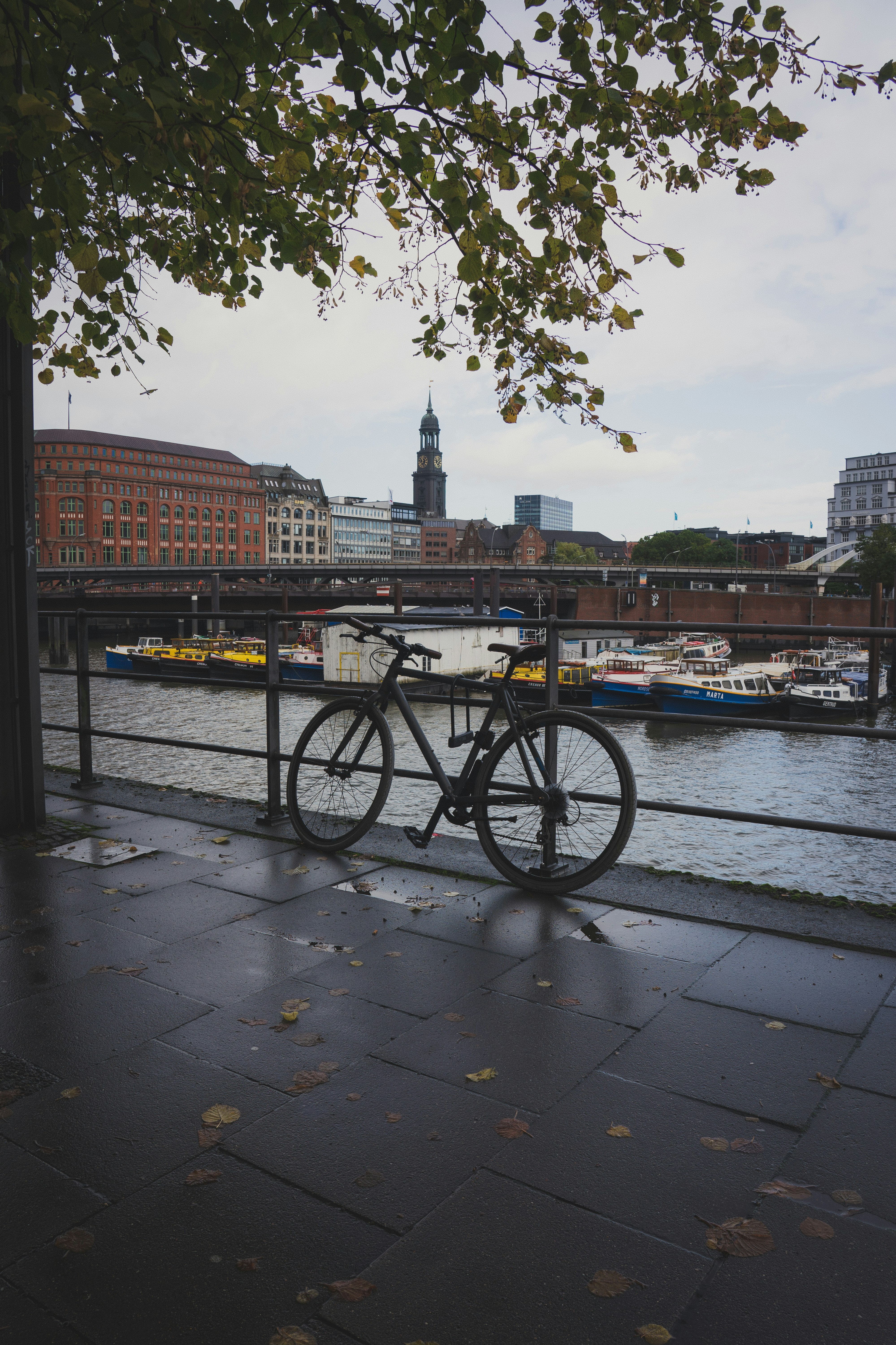Riverfront Pedal: A bicycle framed by boats and brick skyline