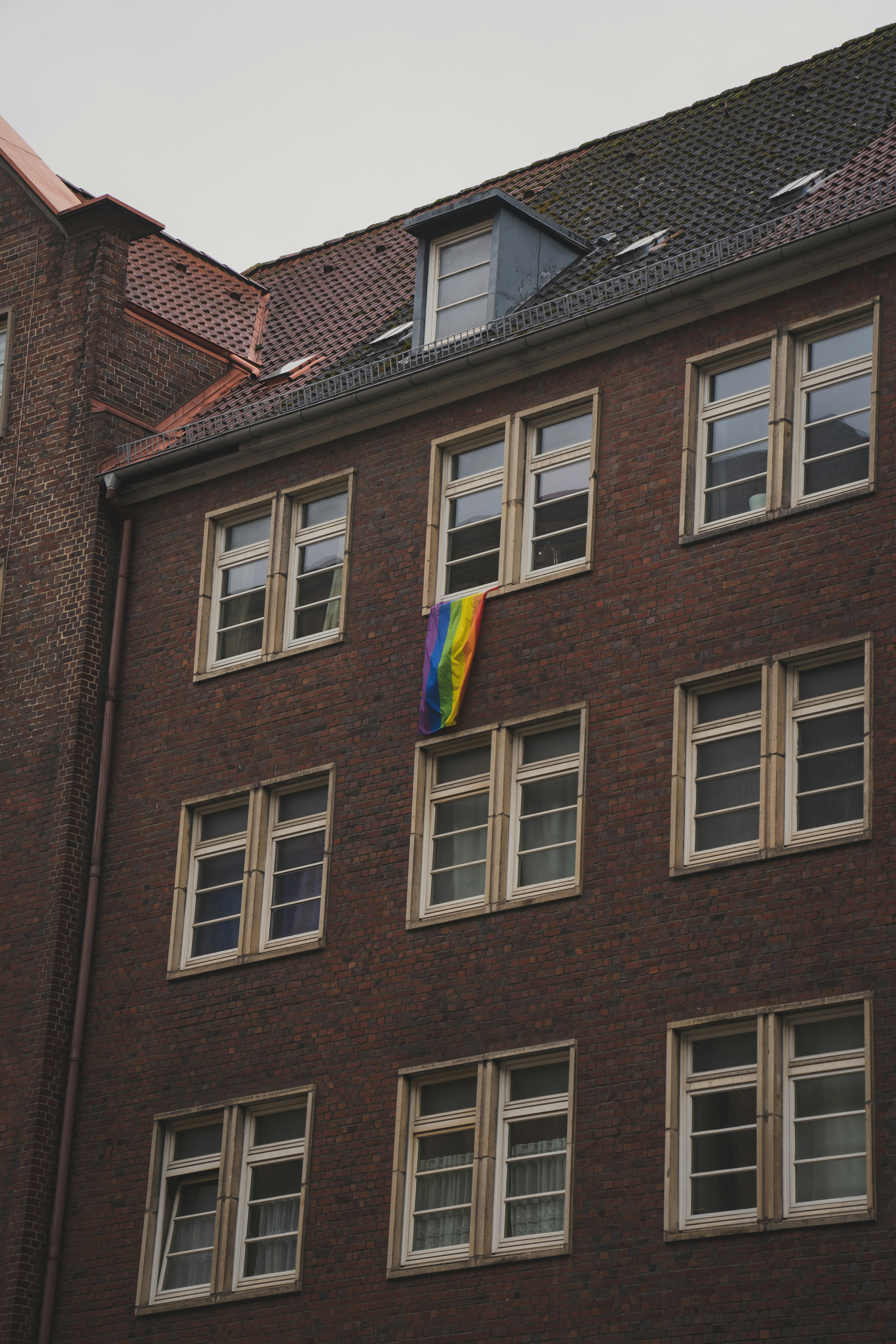 Rainbow Banner on Brick Facade Window Row