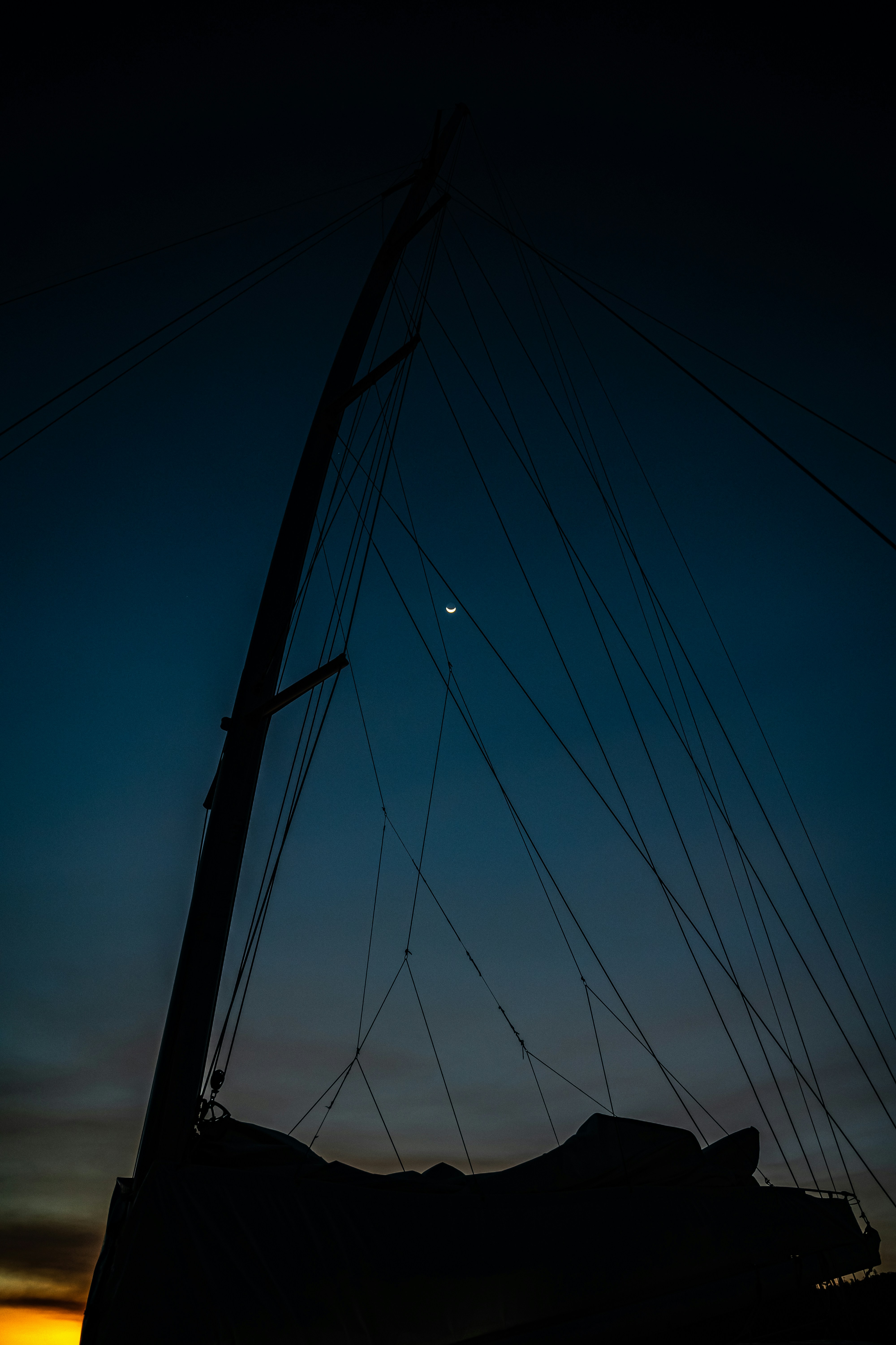 Moonlit Rig: A Sailboat Silhouette against a Gradient Dusk Sky