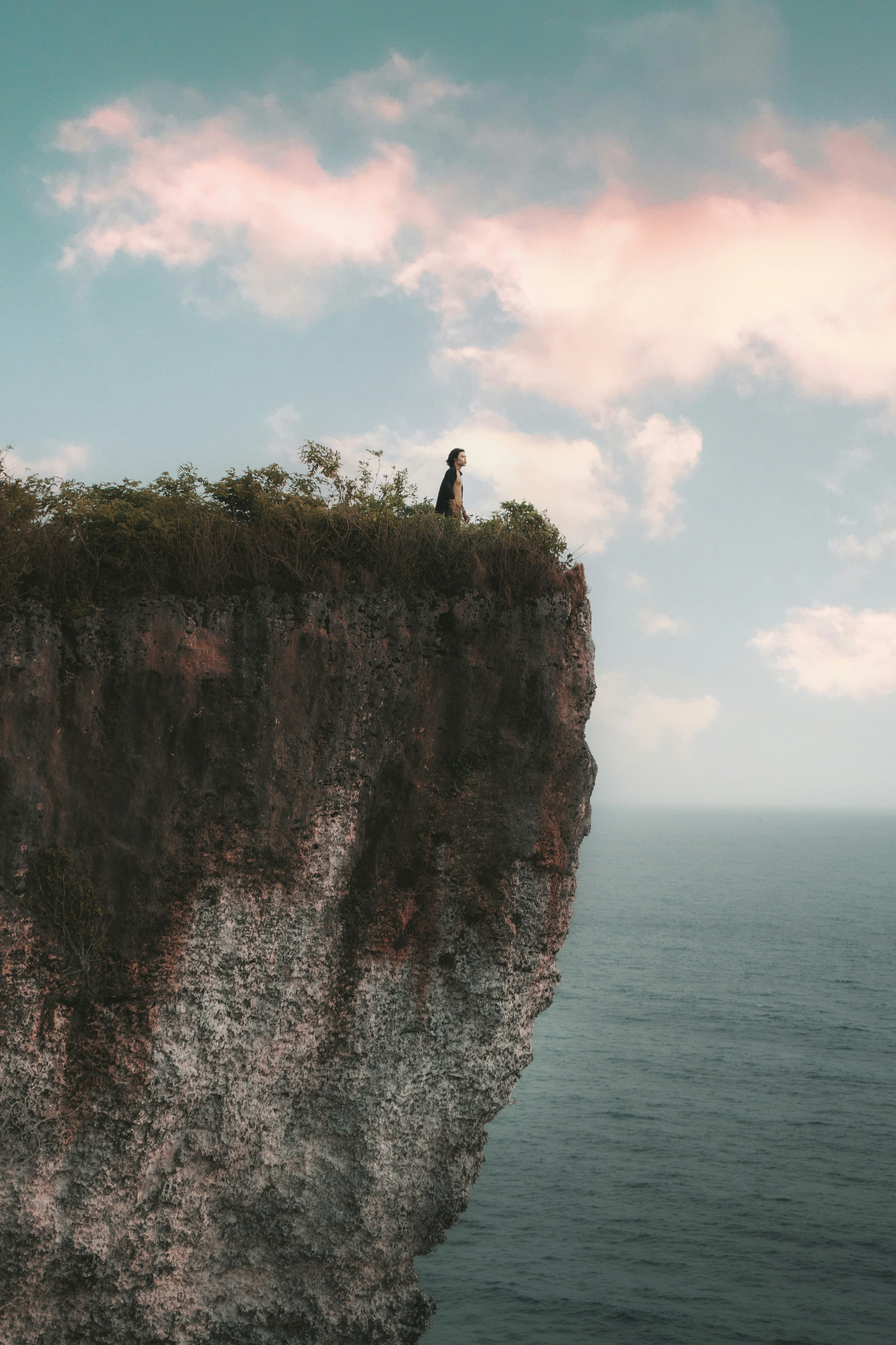Lone Figure at the Cliff's Edge, Overlooking a Quiet Sea