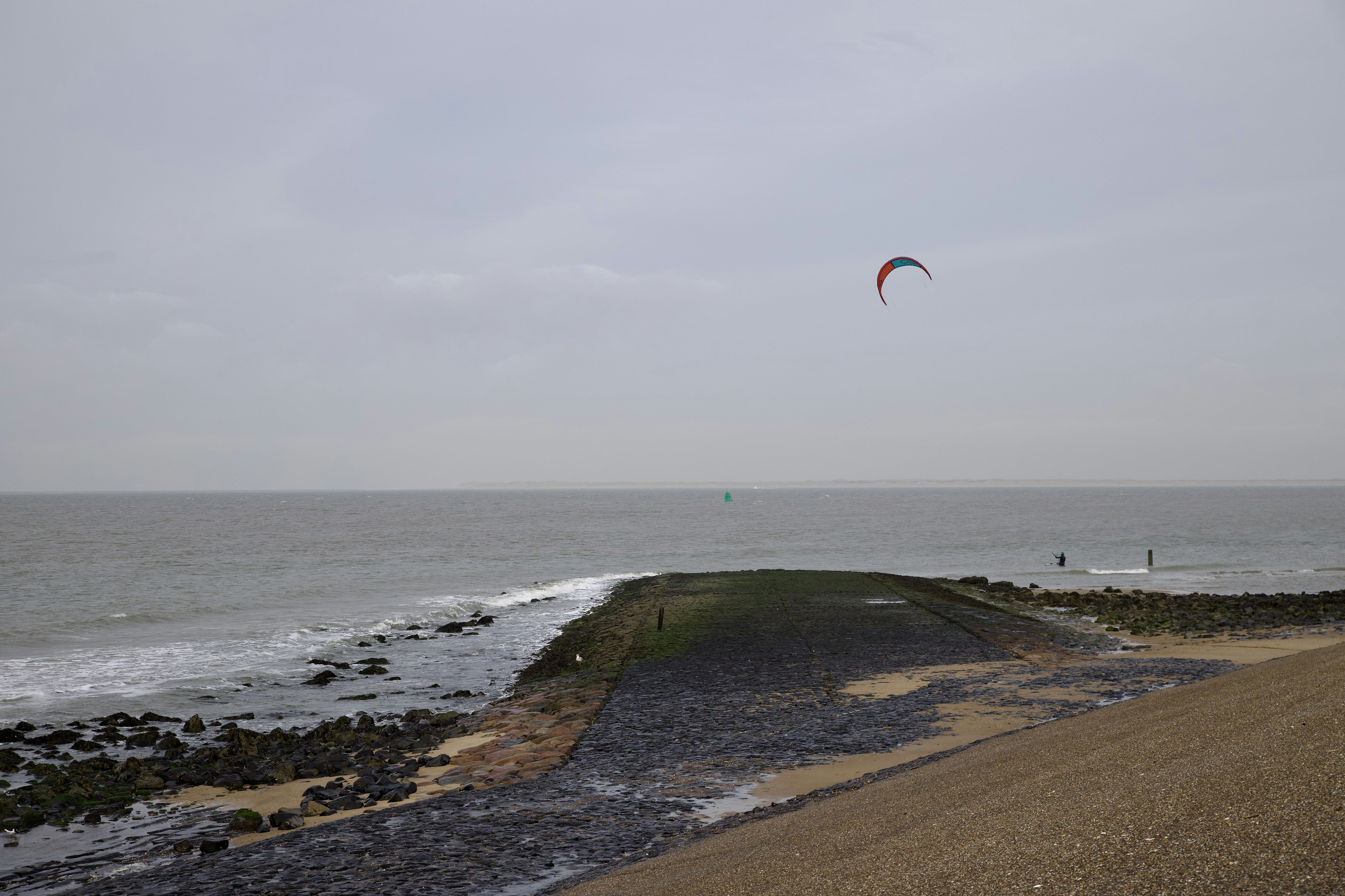 A kite flying over the ocean on a cloudy day photo – Free Den helder ...