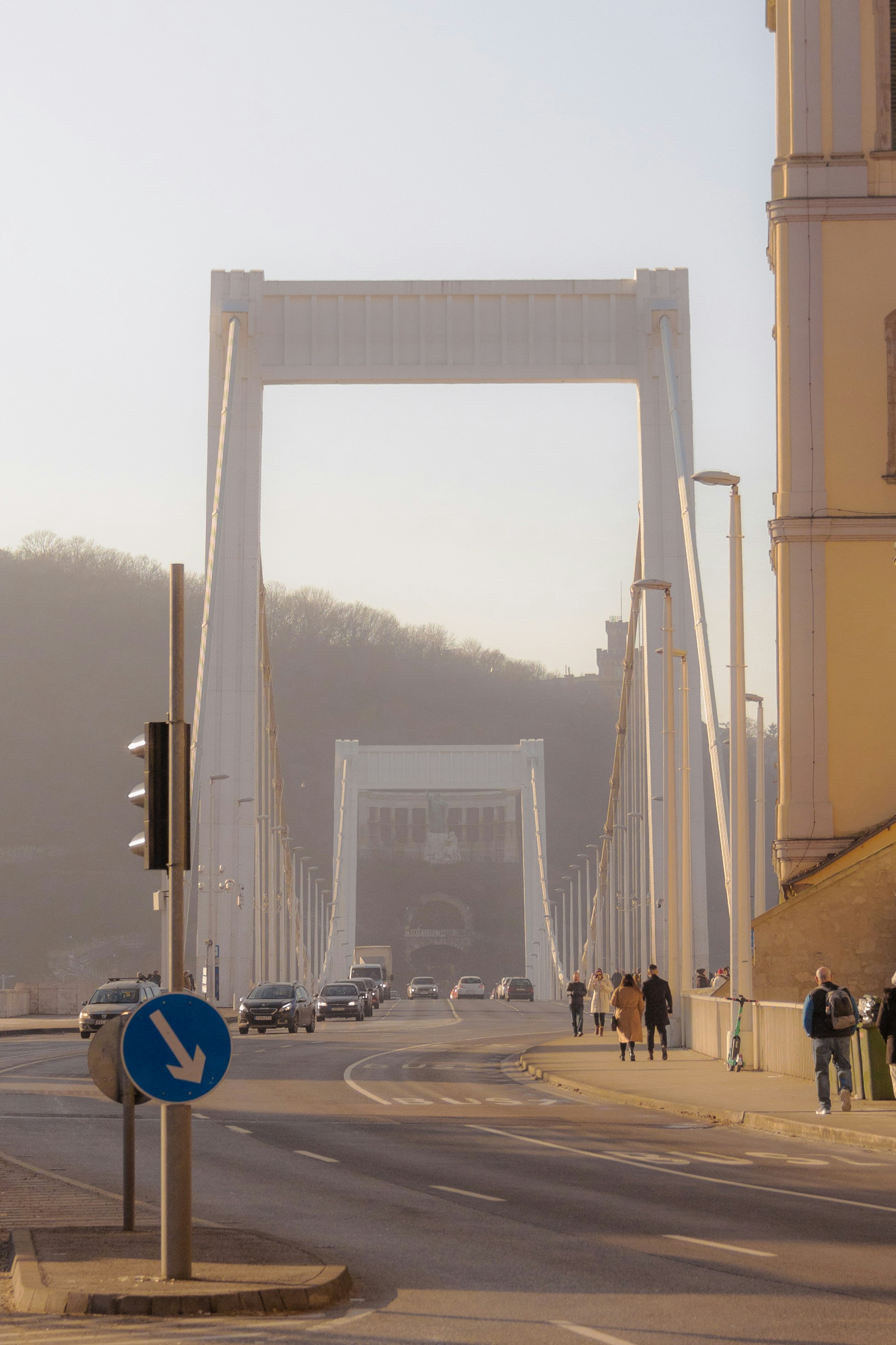 Morning Haze over White Arches: Pedestrians Crossing the City Bridge
